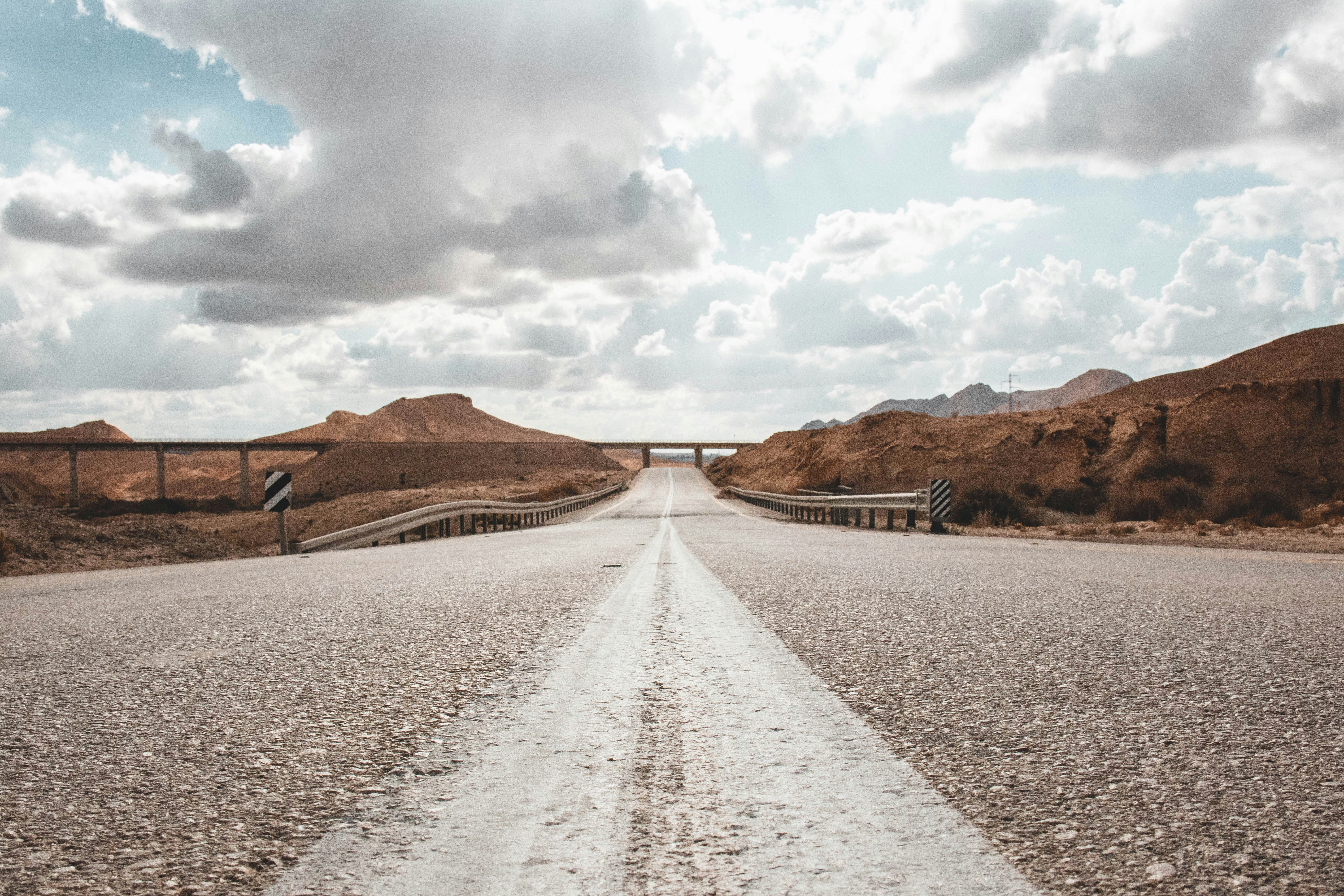 A long straight road with a bridge in the distance photo – Free Road ...