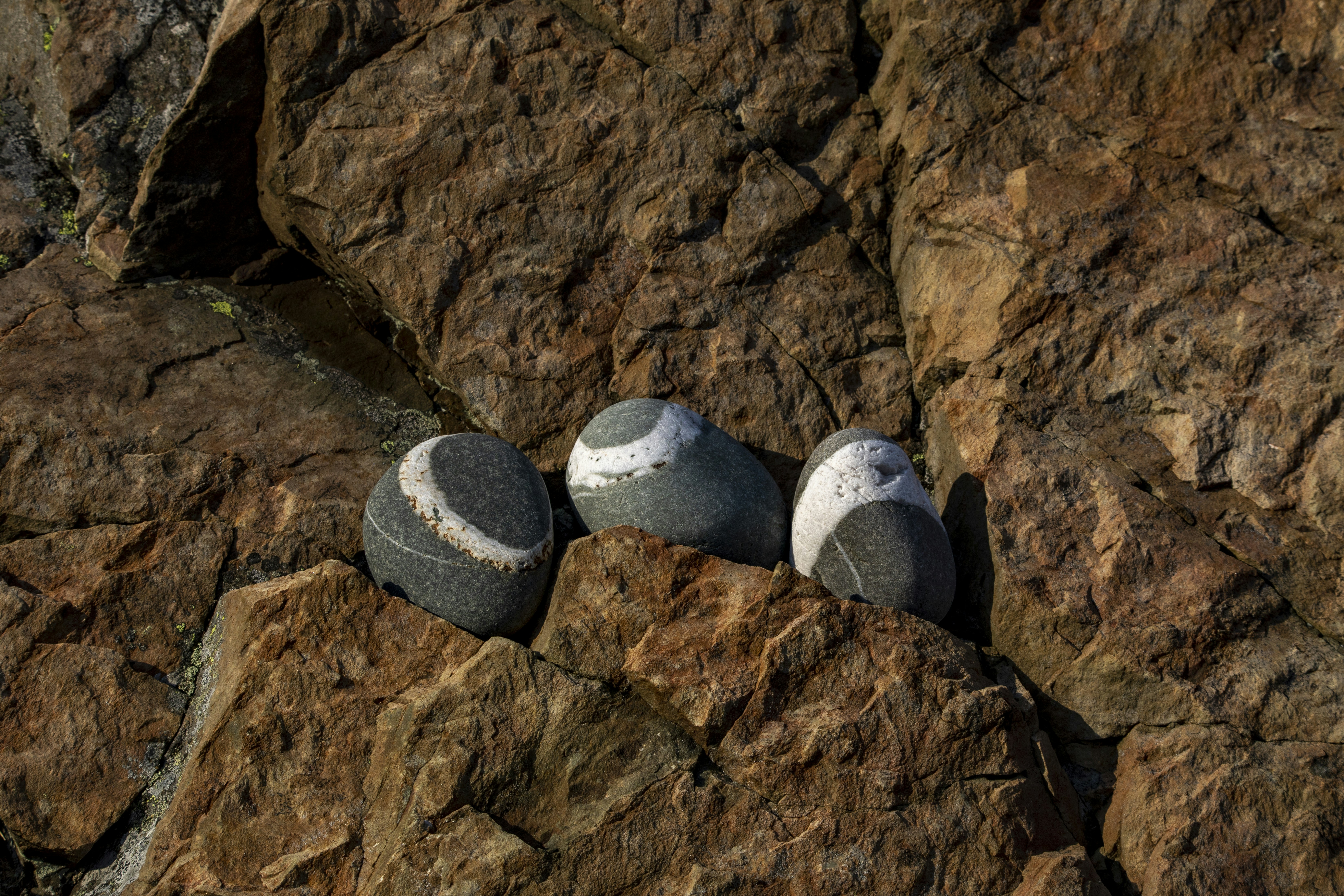 Trio of Pebbles Nestled in Weathered Red Rock