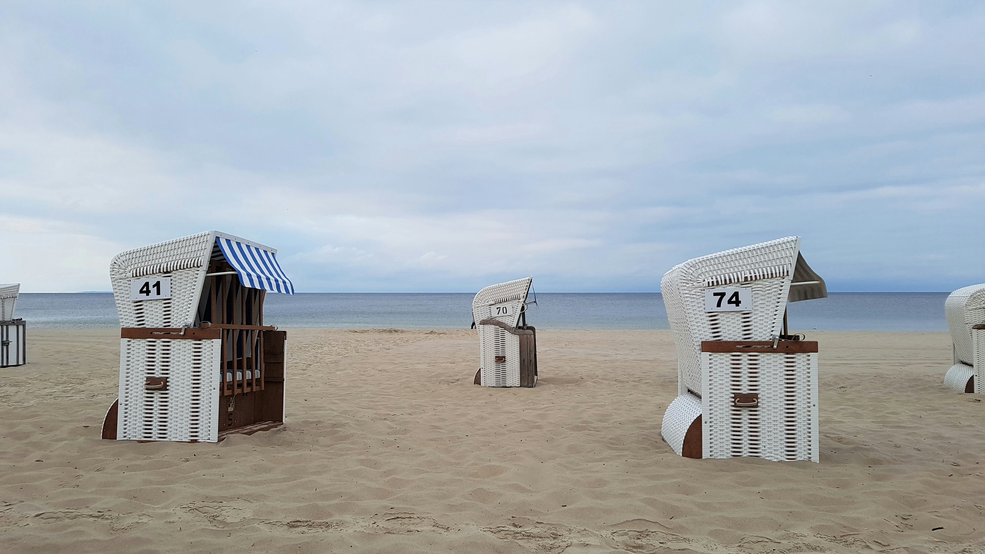 Row of striped beach chairs under an overcast horizon