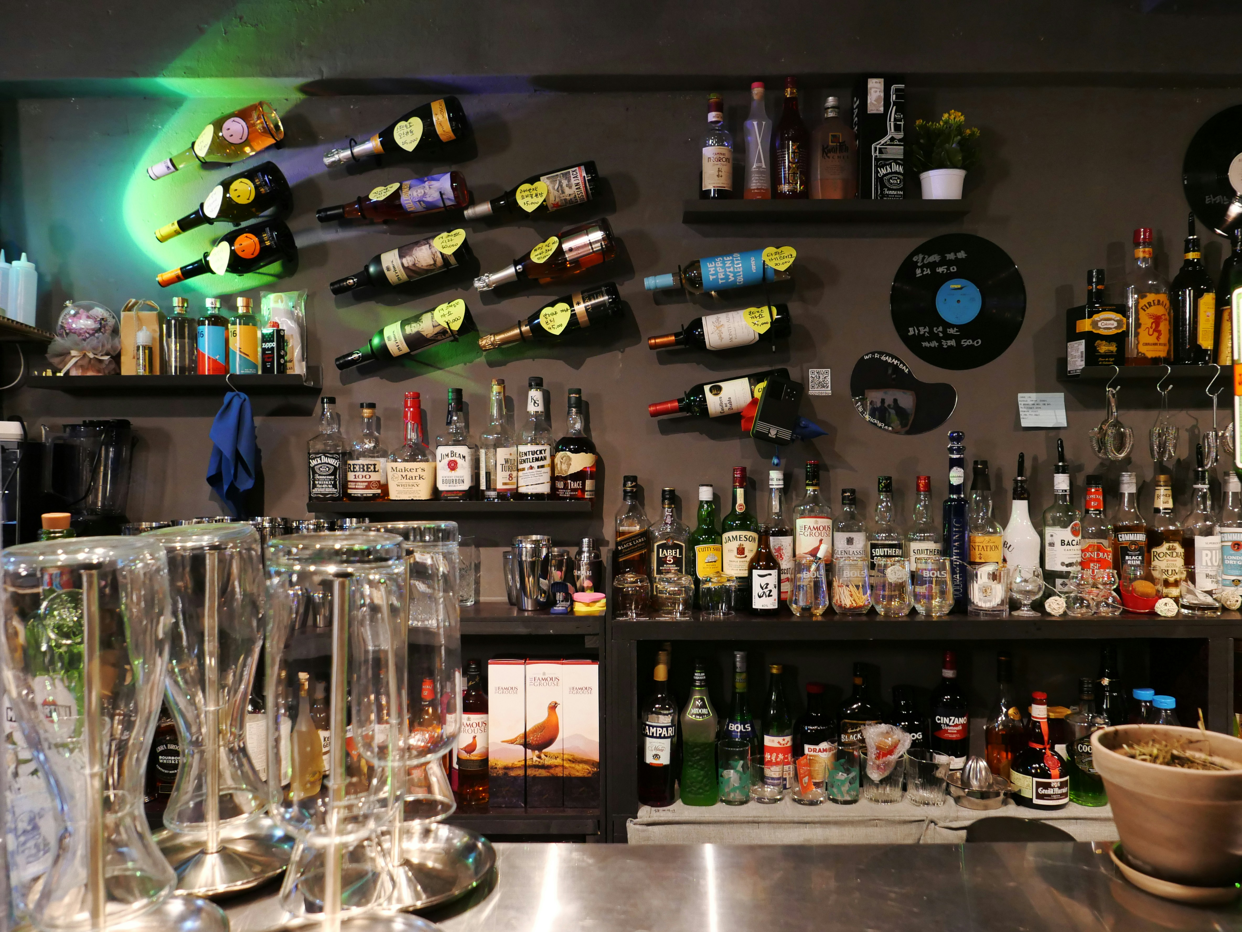 Un bar lleno de muchas botellas y vasos foto – Imagen de Vino gratuita ...