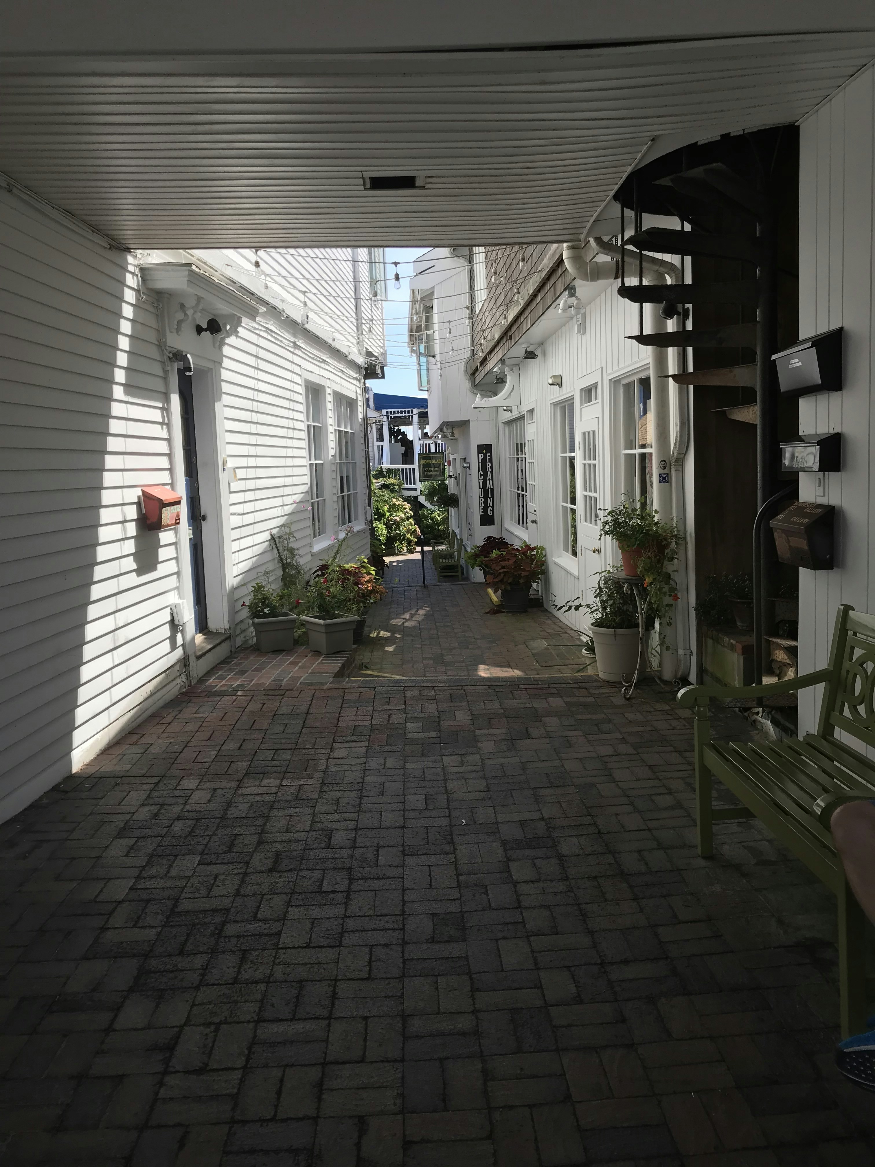 A brick walkway between two white houses photo – Free Grey Image on ...