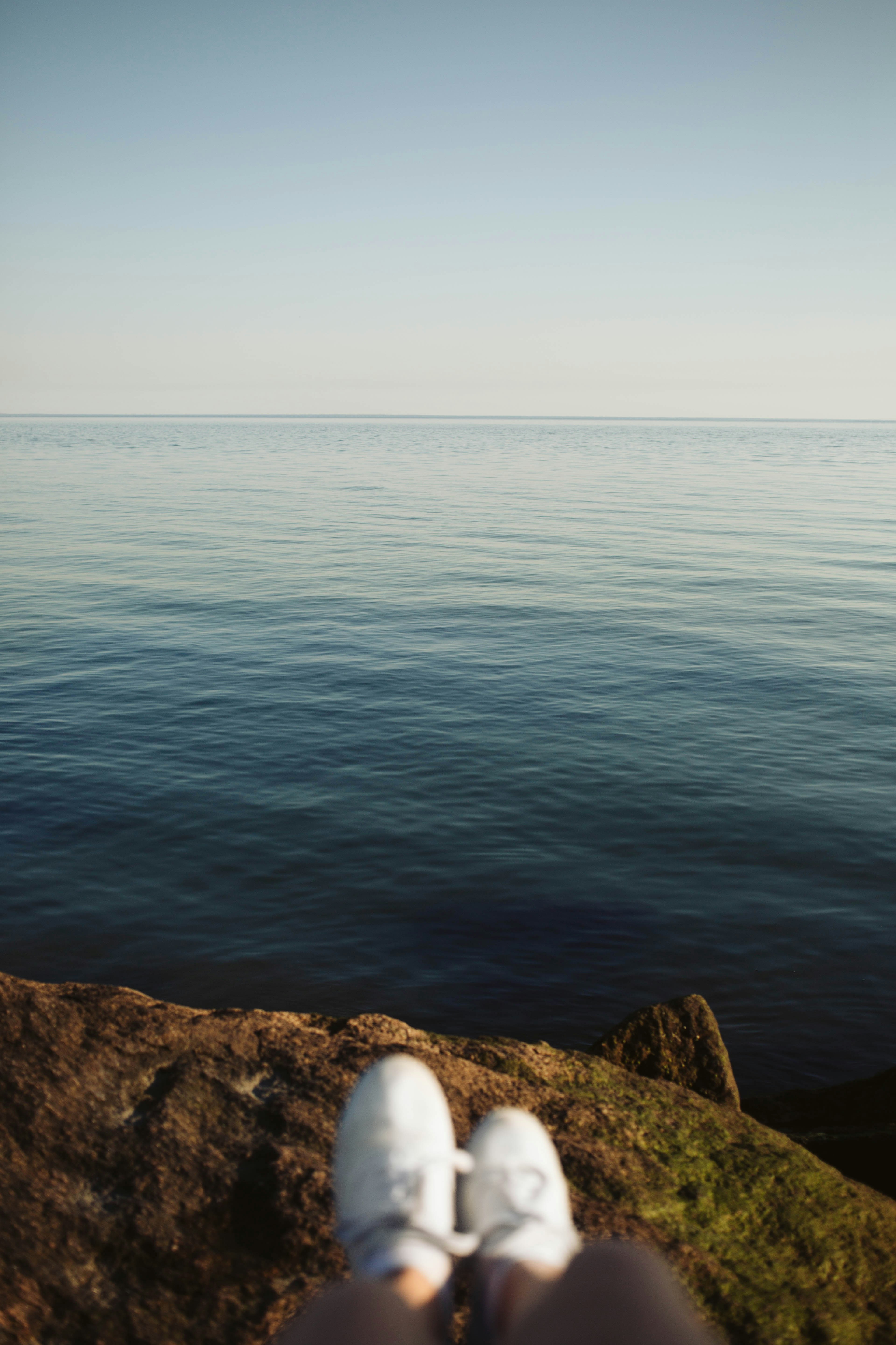 Edge of Stillness: Feet Over Sea and Stone