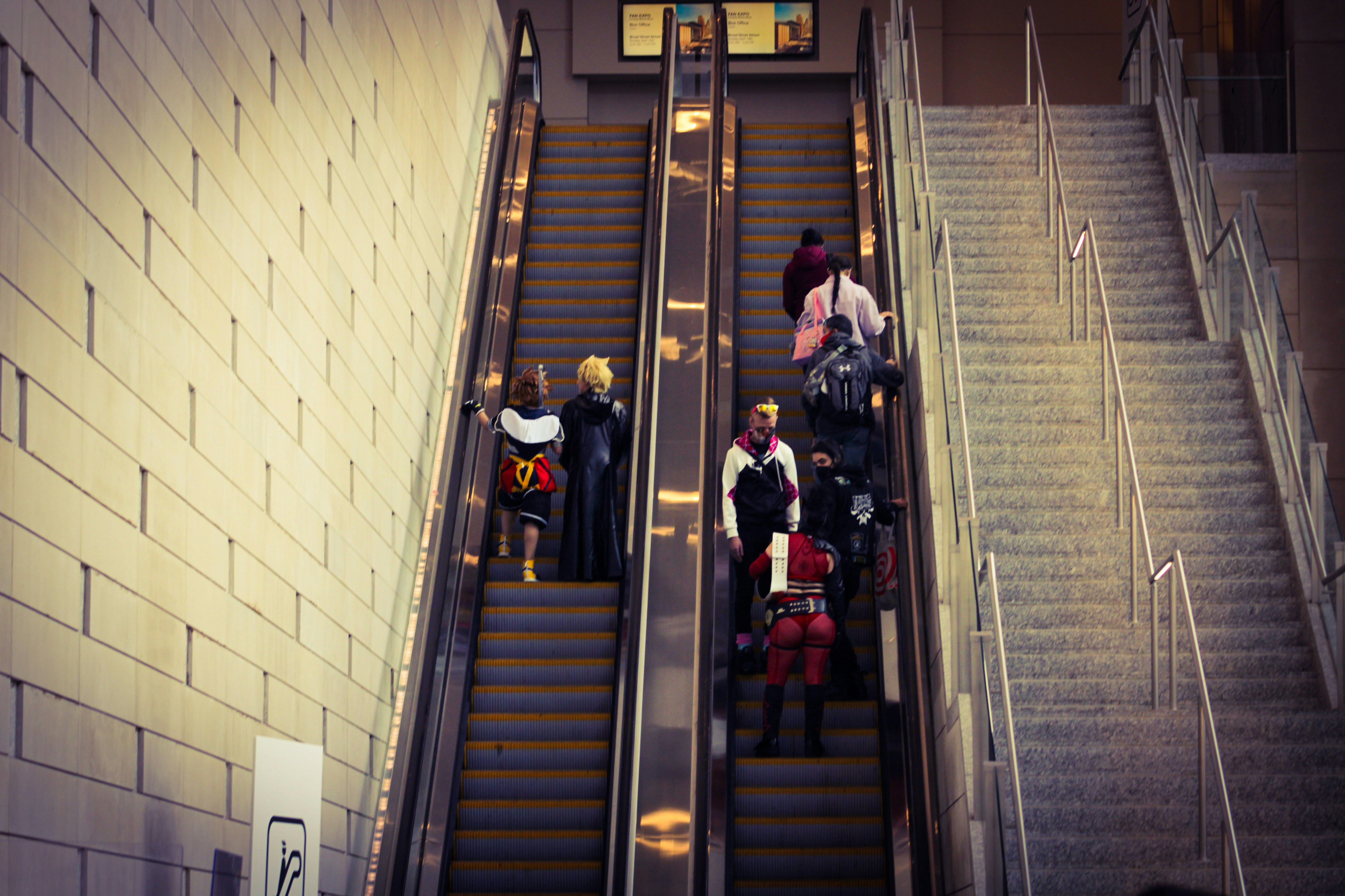A group of people riding down an escalator photo – Free Staircase Image ...