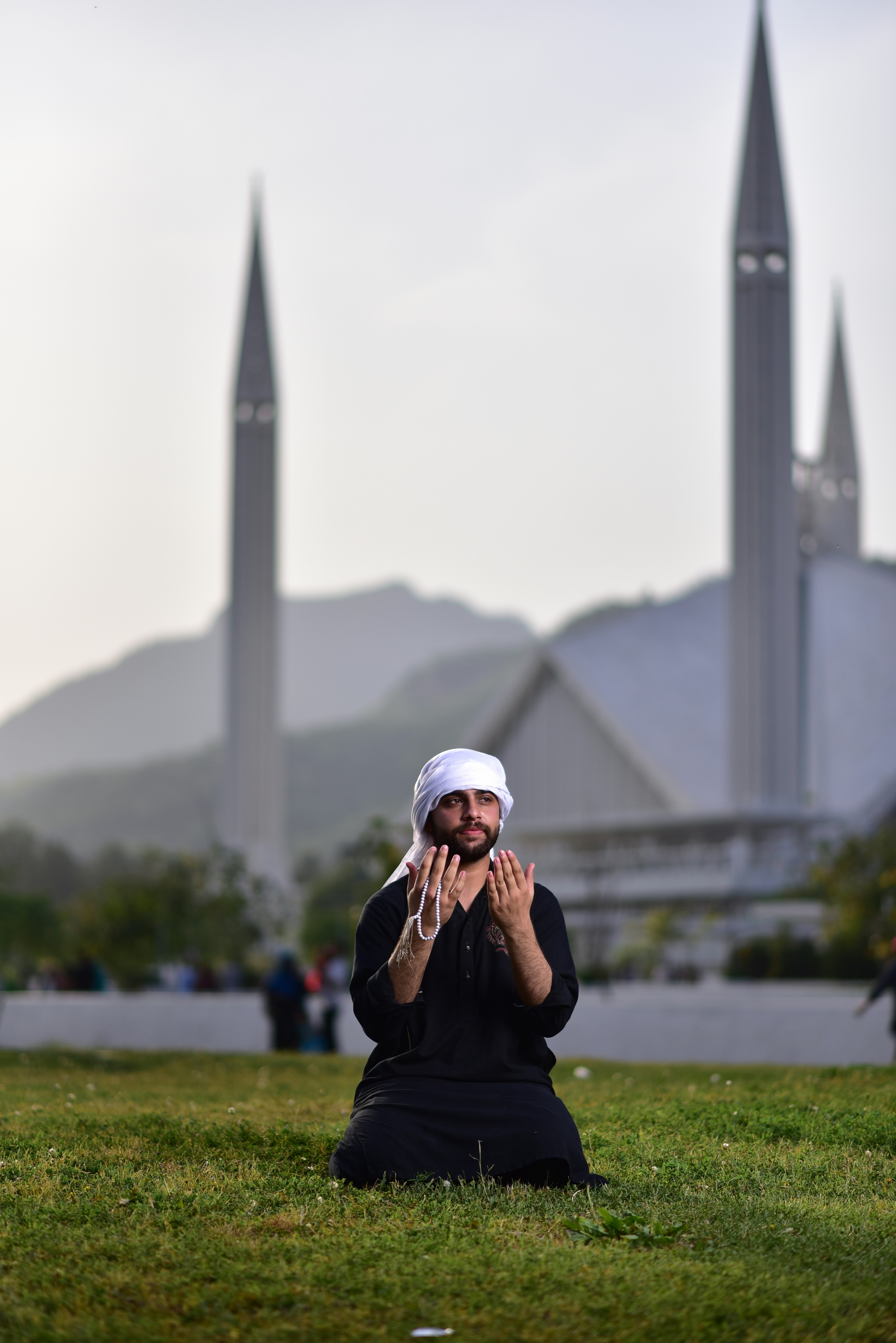 Kneeling in Prayer Before Monumental Minarets