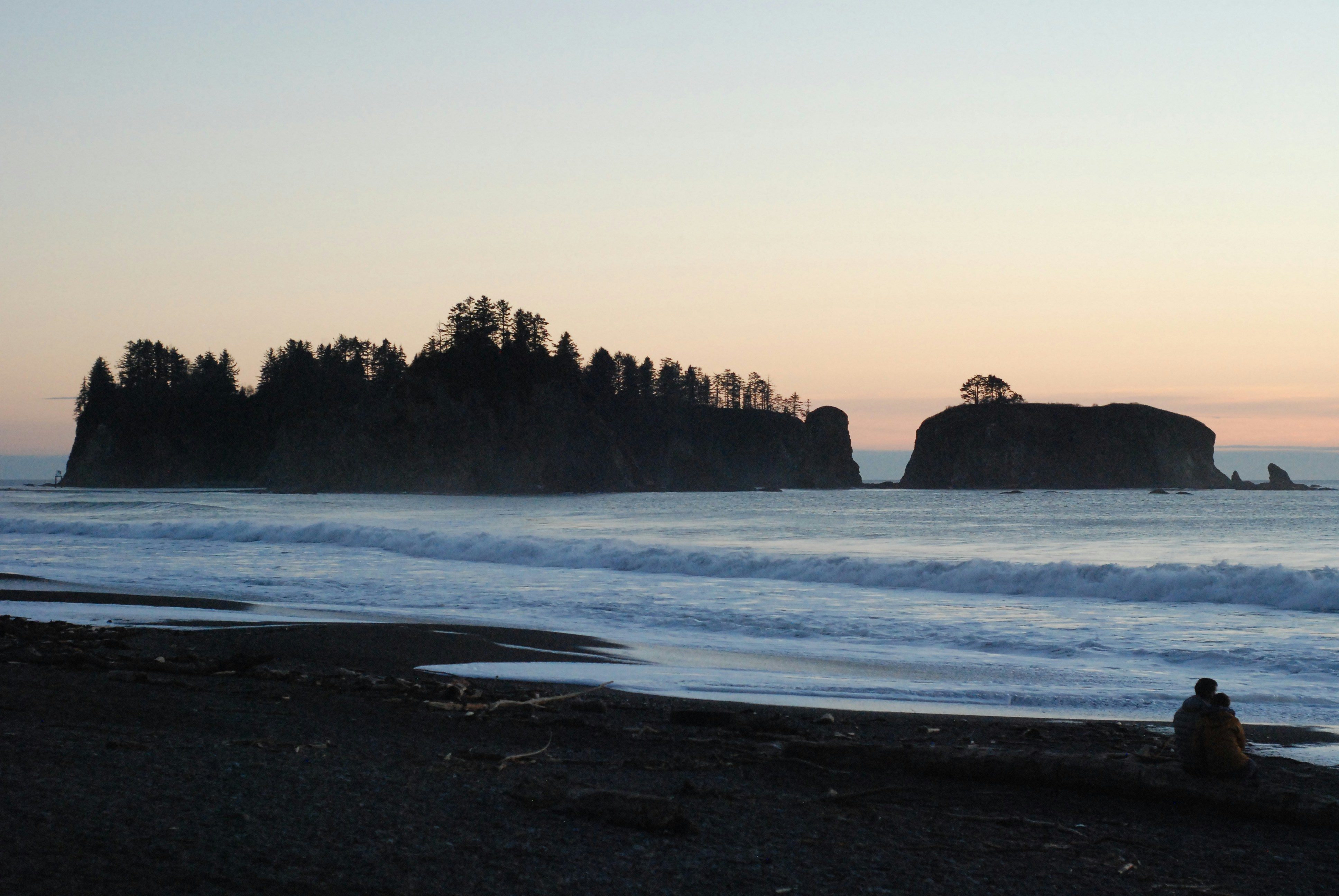 A person sitting on the beach watching the waves photo – Free People ...