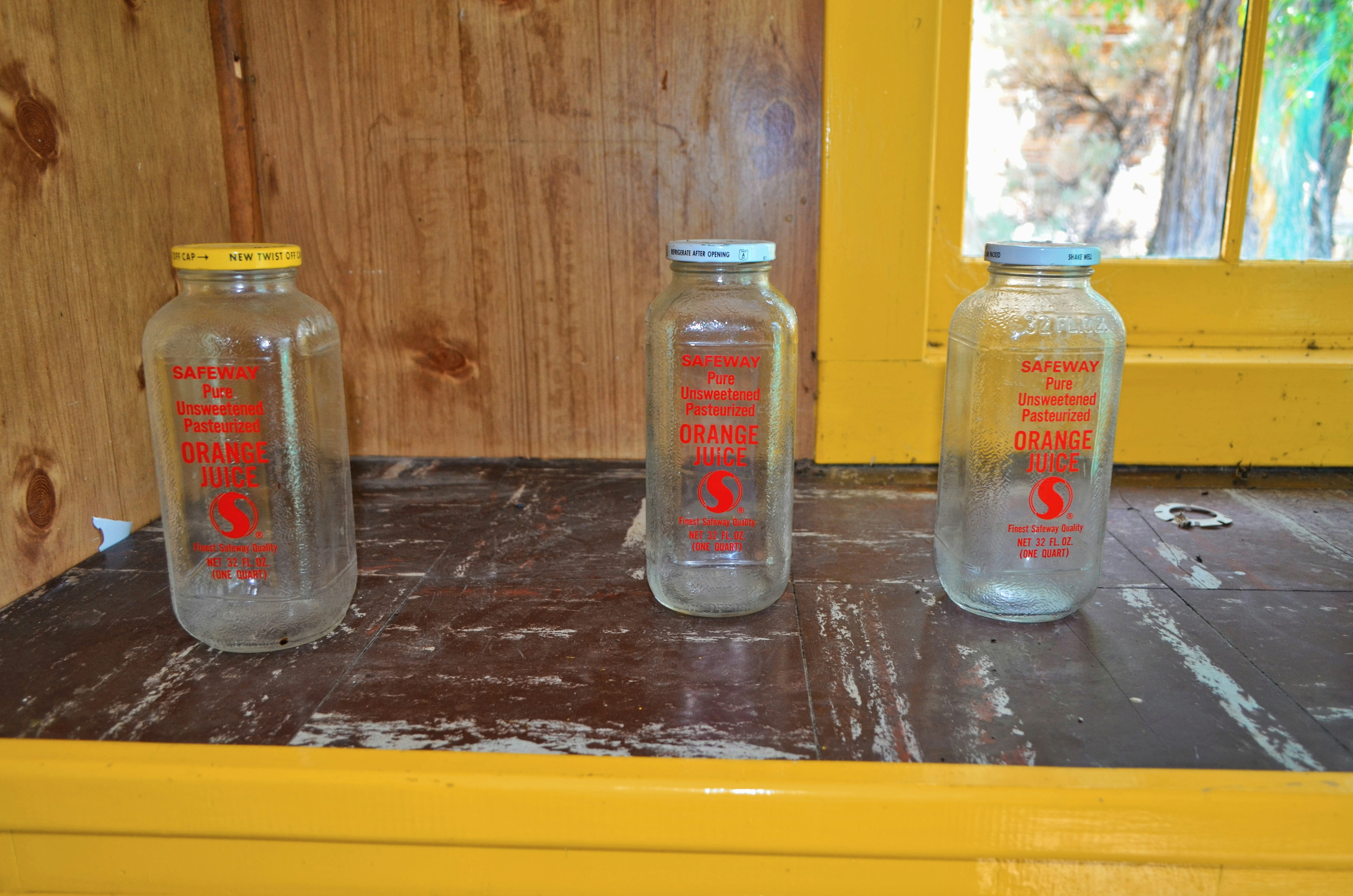 Three Citrus Bottles on a Weathered Counter