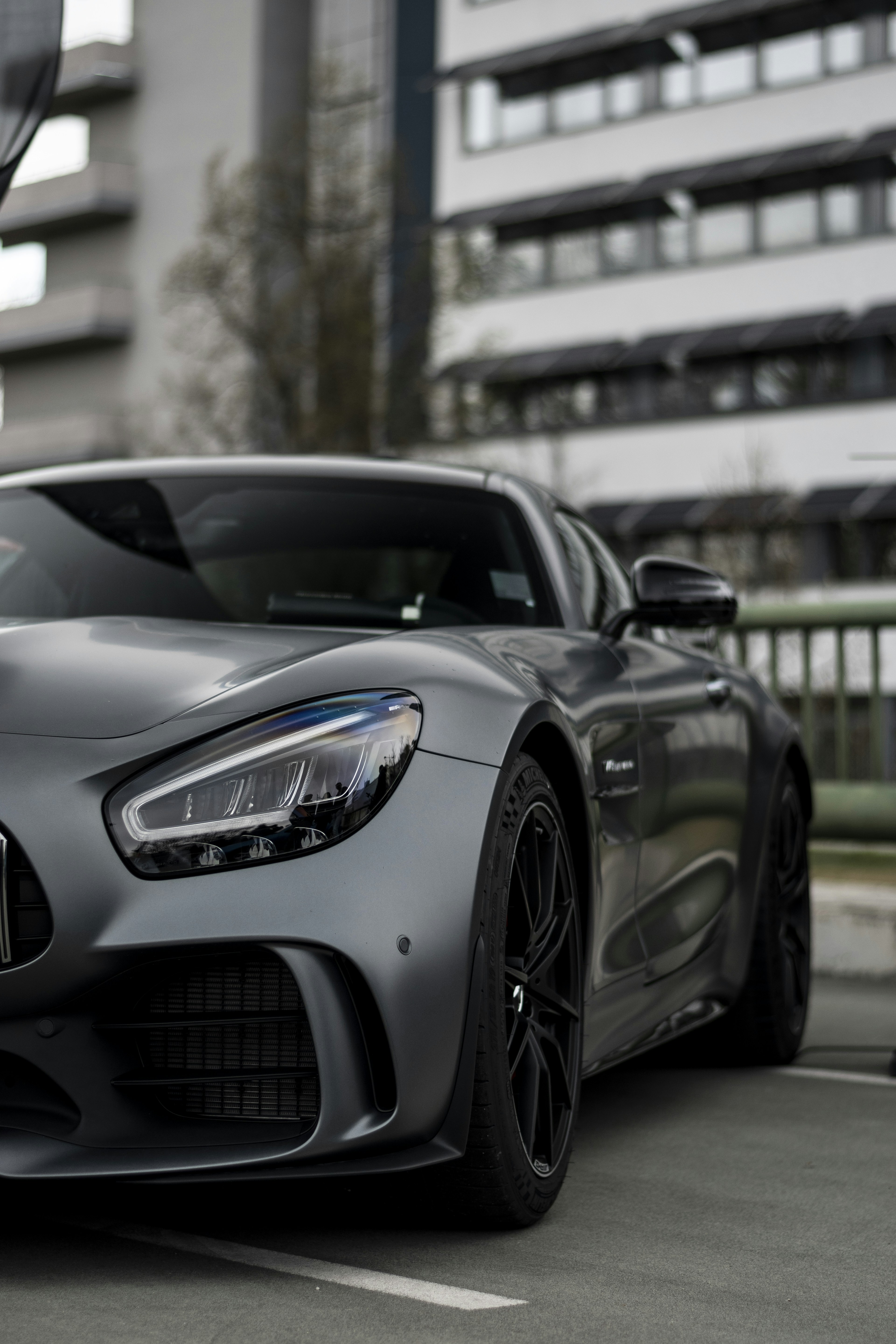 A grey sports car parked in a parking lot photo – Free Grey Image on ...