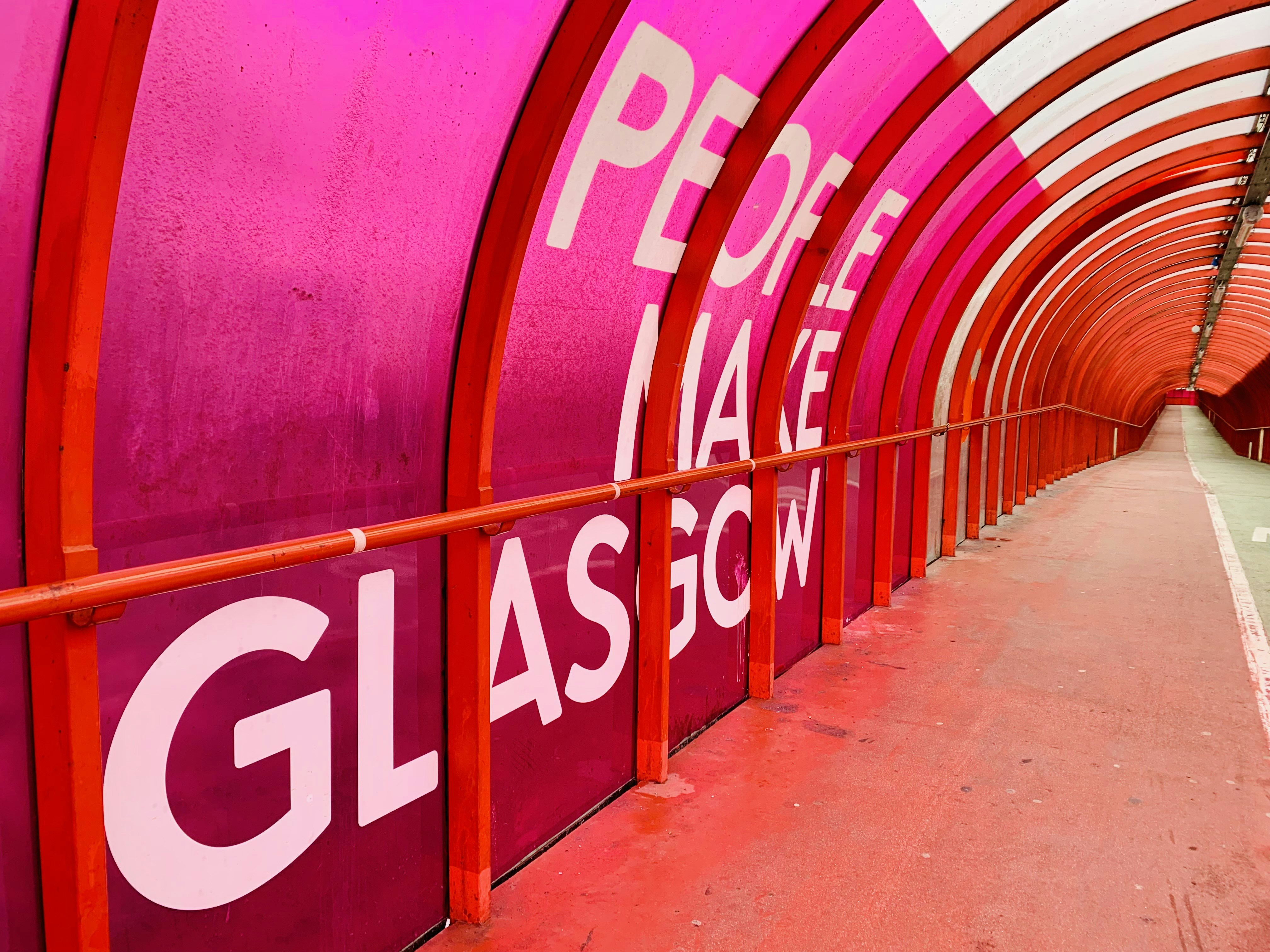 Vibrant walkway adorned with bold typography, showcasing the phrase 'People Make Glasgow' against a striking pink backdrop.
