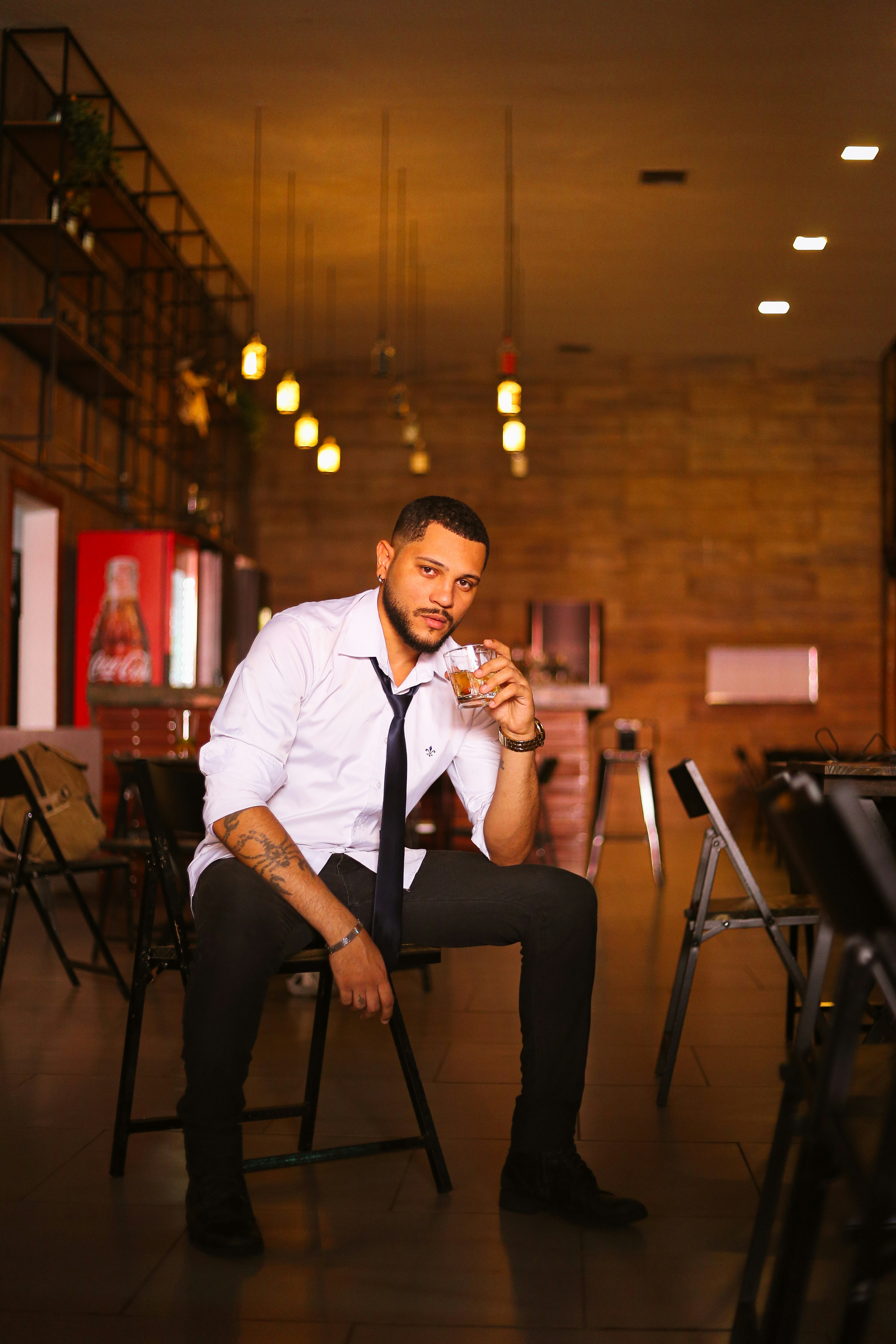 Un hombre sentado en una silla sosteniendo una copa de vino foto ...