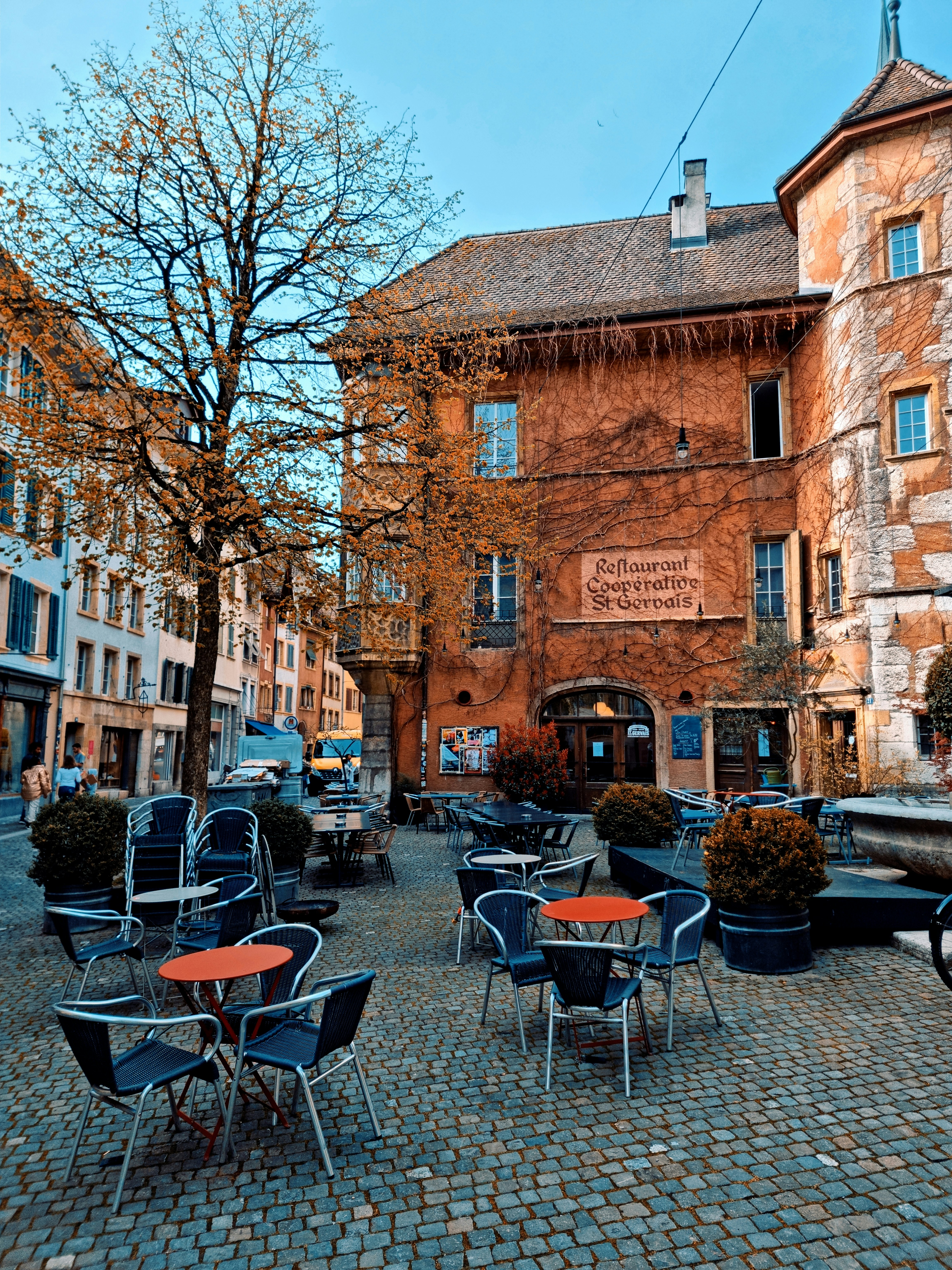 Cobbled Courtyard Café Adrift in Autumnal Brick and Blue Chairs