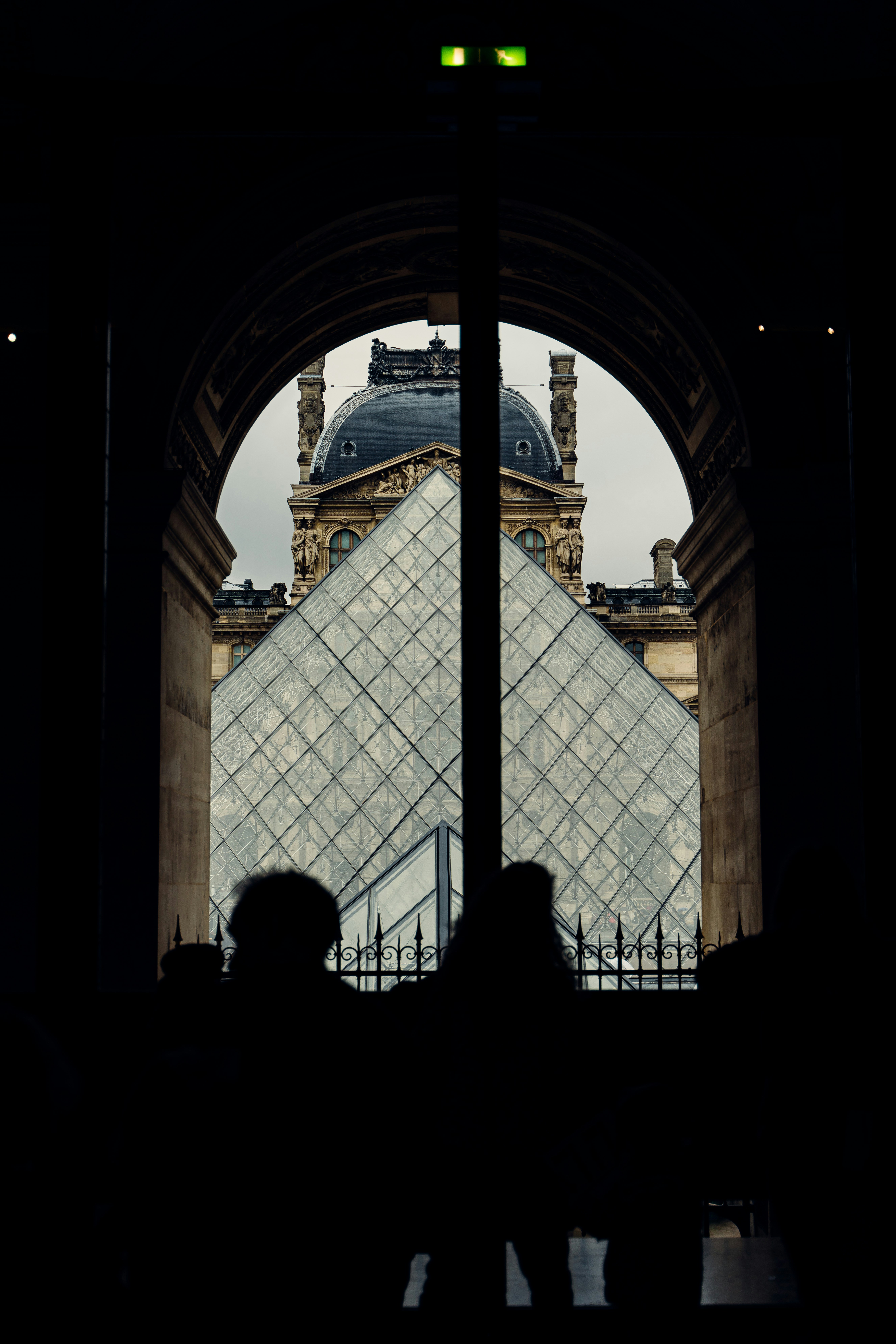 Through the Arch: Louvre Pyramid Framed by a Silent Gallery