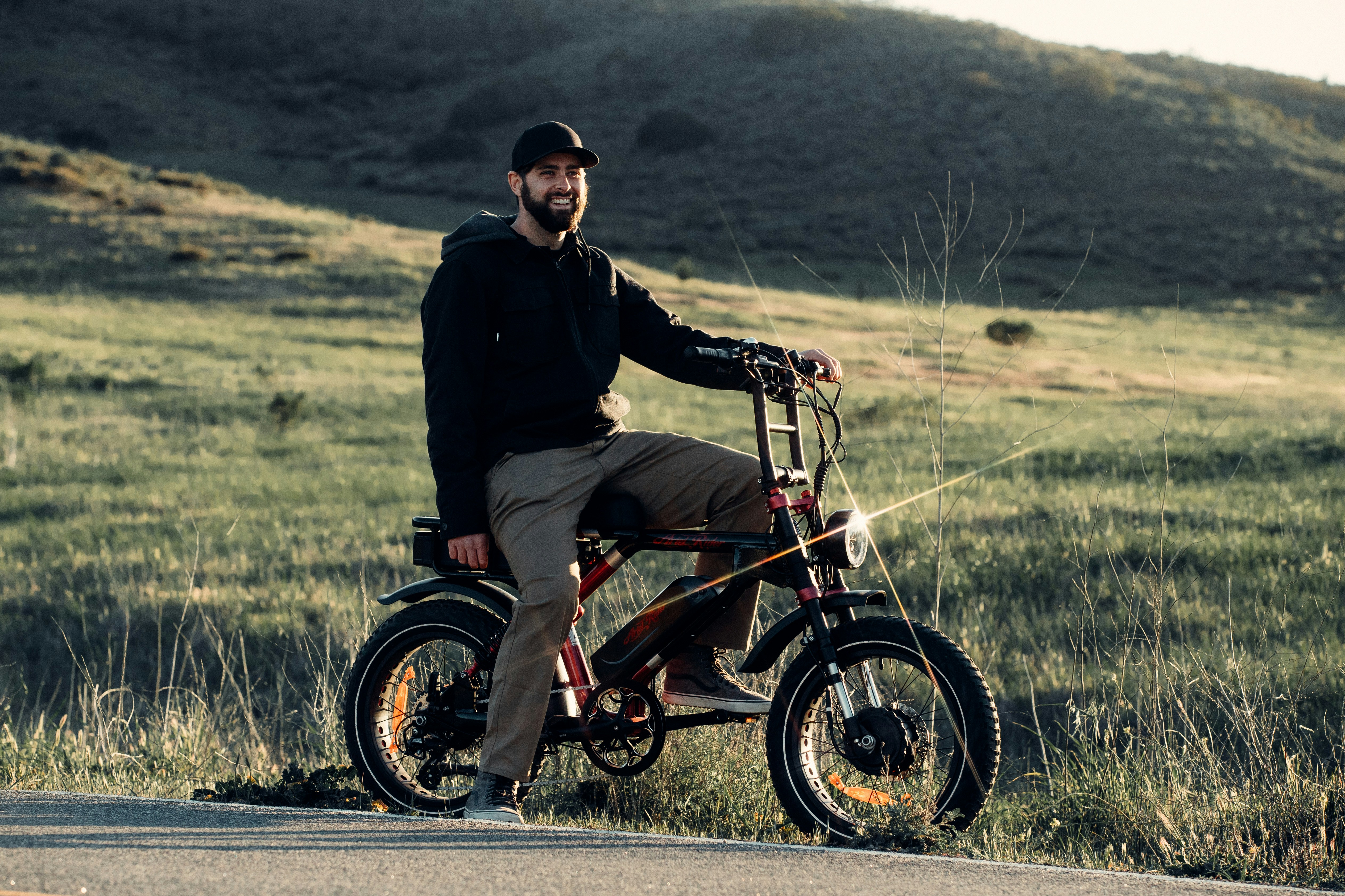 Rider on a grassy hillside: a lone cyclist pauses beside a vintage-style bike