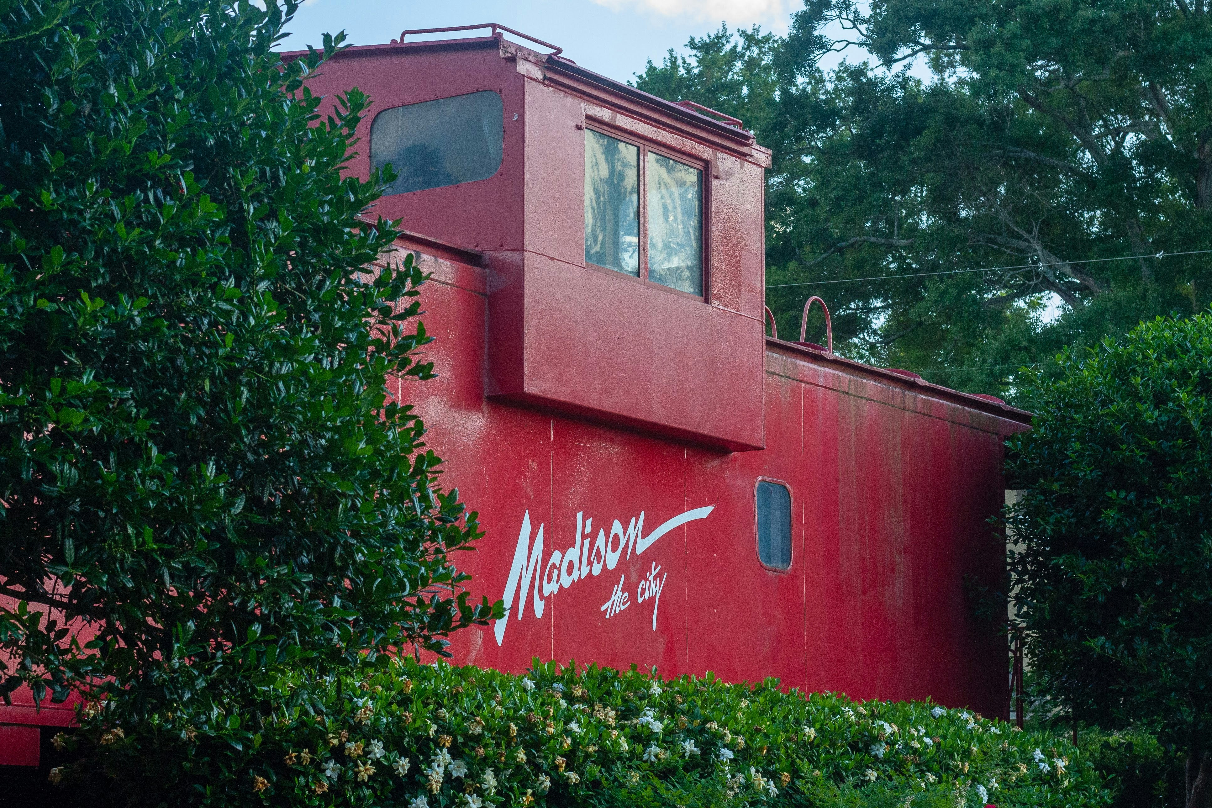 Red Caboose in Greenery: Madison Signage on a Quiet Car