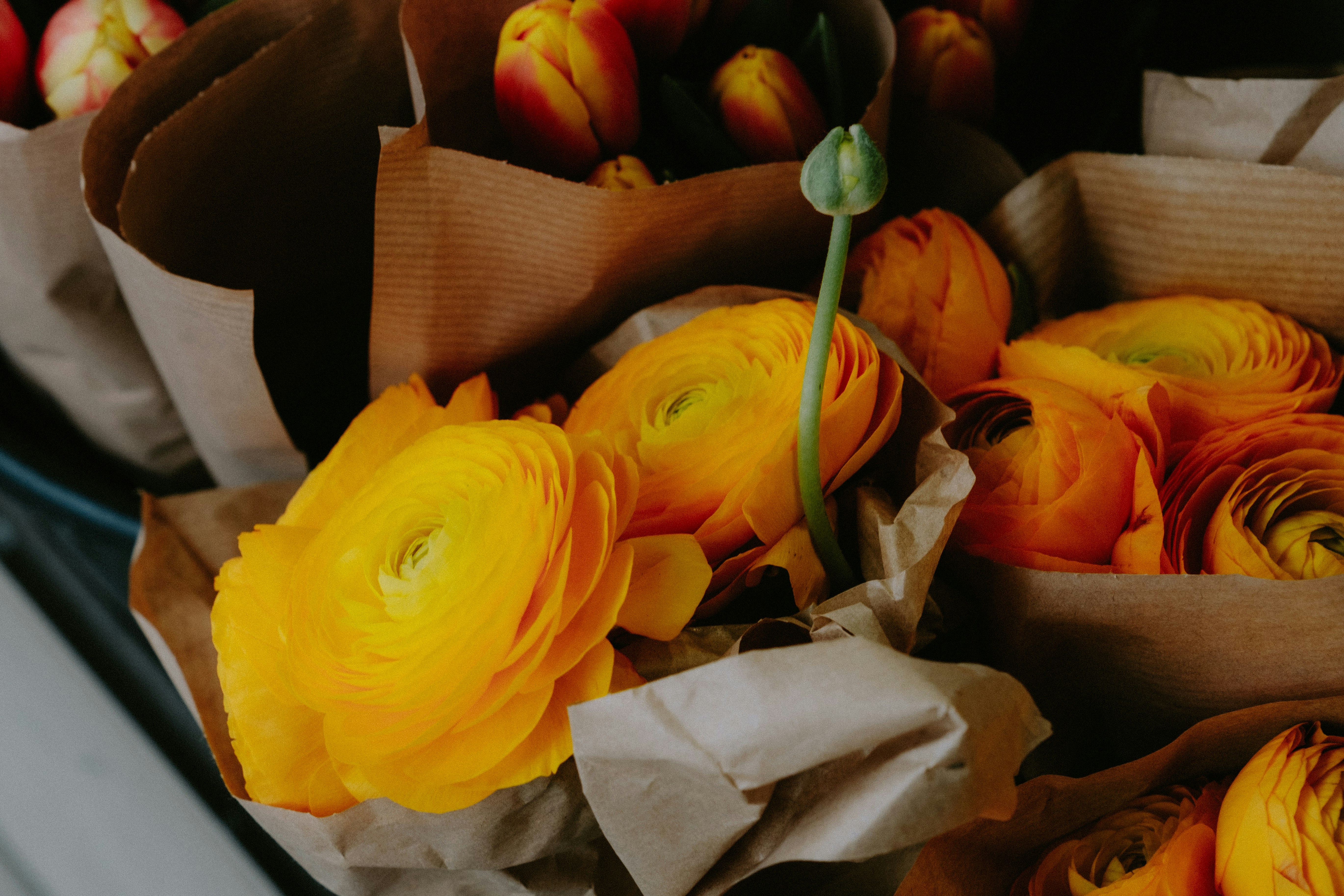 Golden Ranunculus bouquets in brown craft paper