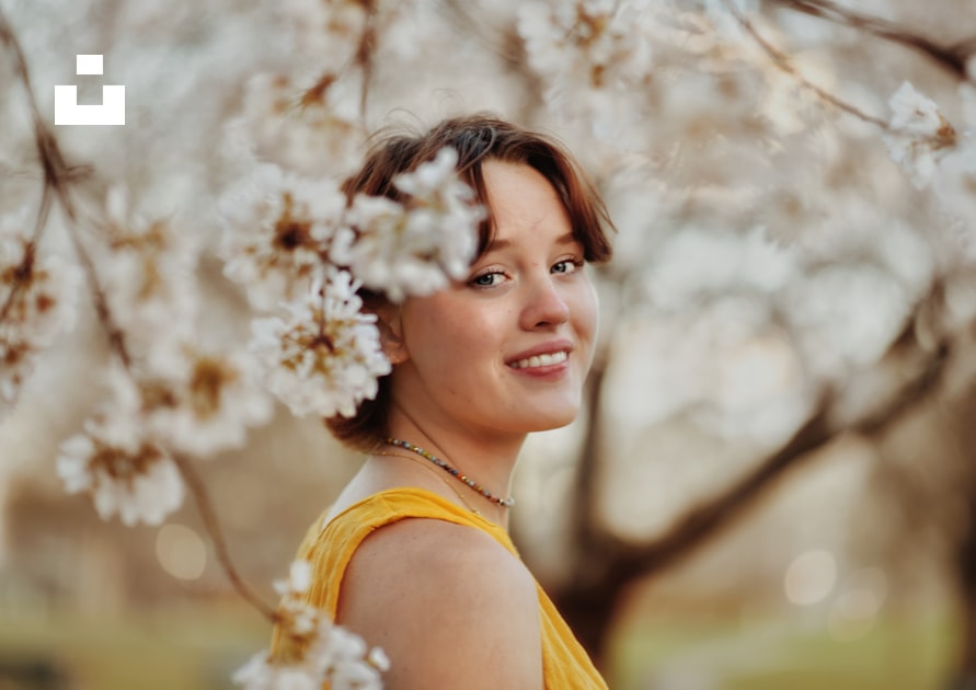 Foto Una Mujer Parada Debajo De Un árbol Con Flores Blancas Imagen