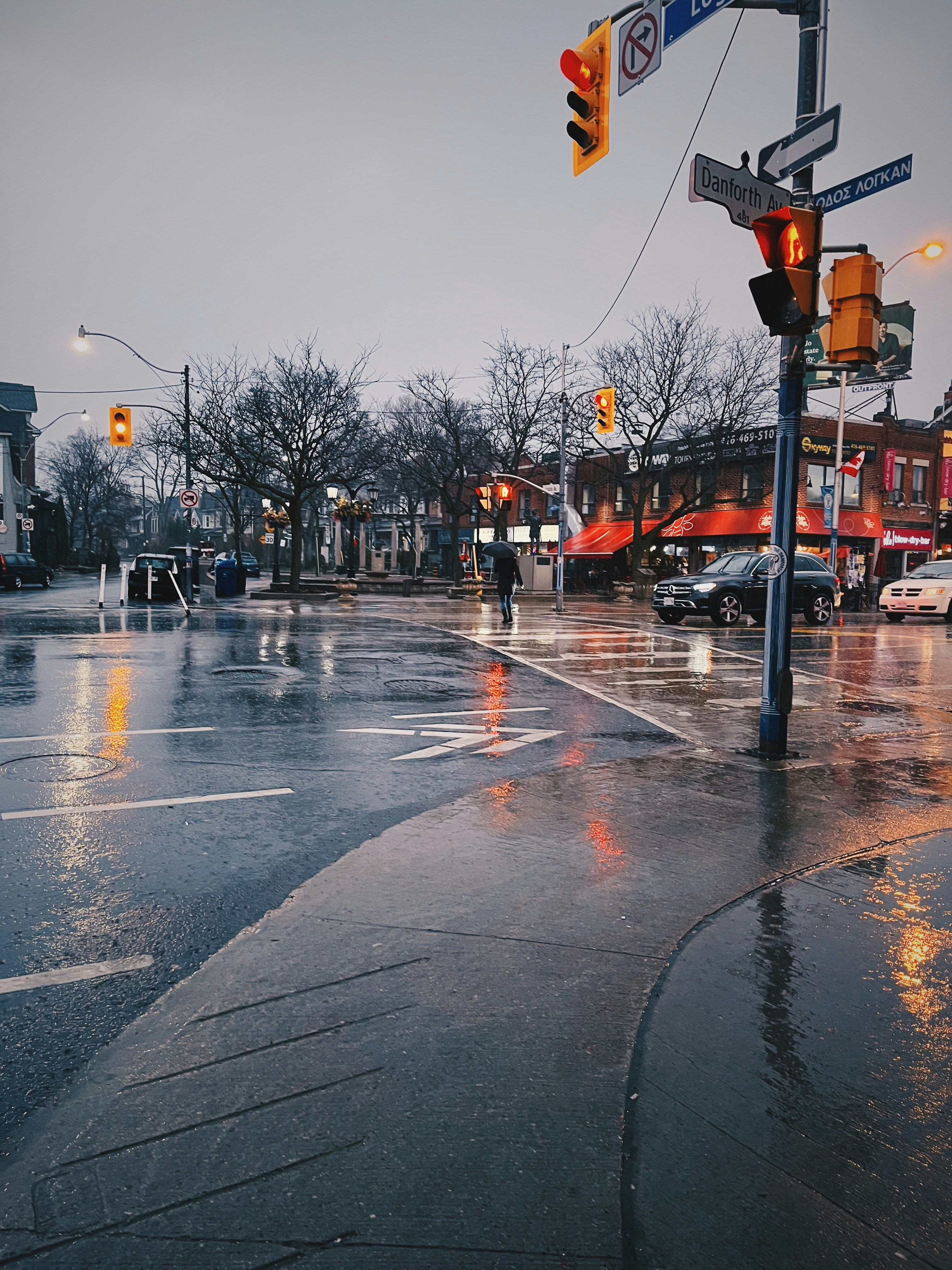 A wet street corner with a traffic light and street signs photo – Free ...