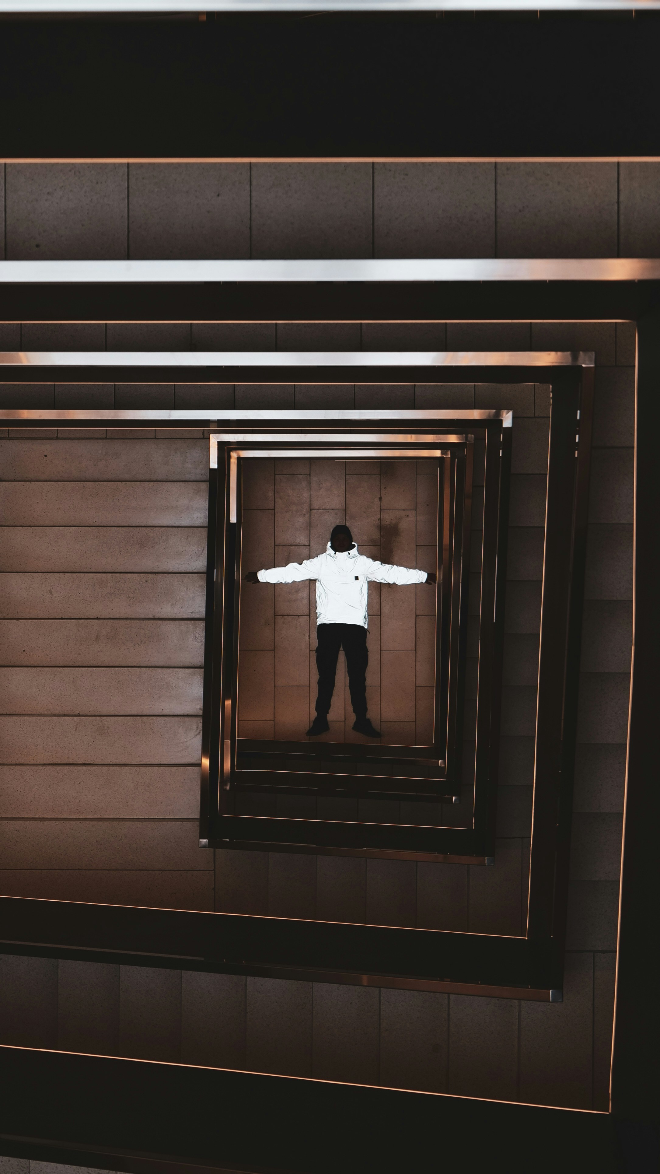 Centered in the Spiral: A Solo Figure Standing Arms Open in a Geometric Atrium