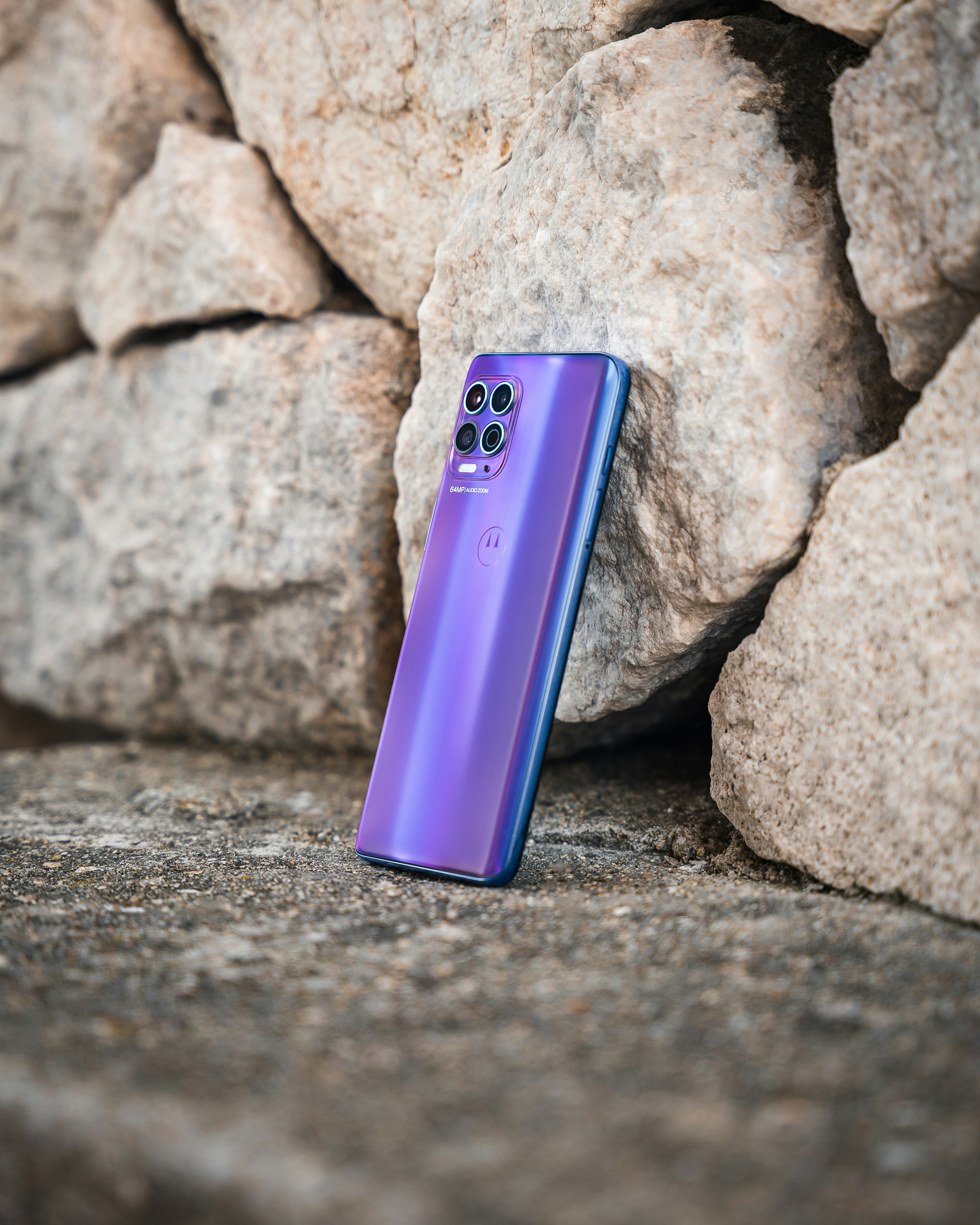 A purple cell phone sitting on top of a rock photo – Free Motorola g100 ...