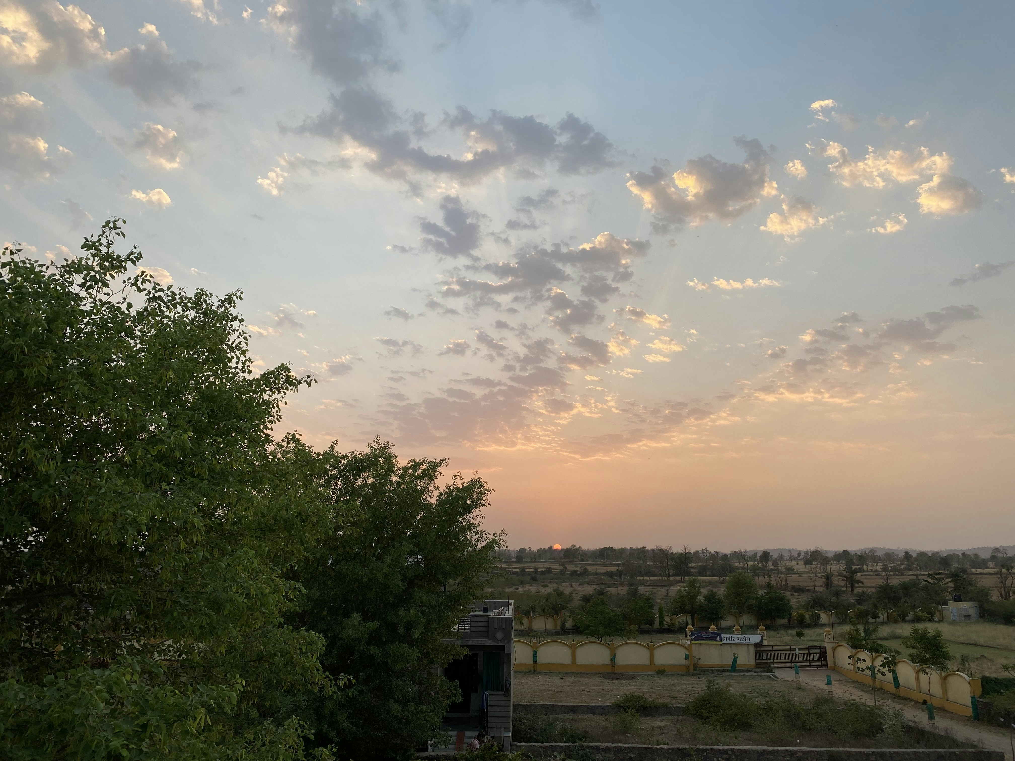 The sun is setting over a field with trees photo – Free Fort dhariyawad ...