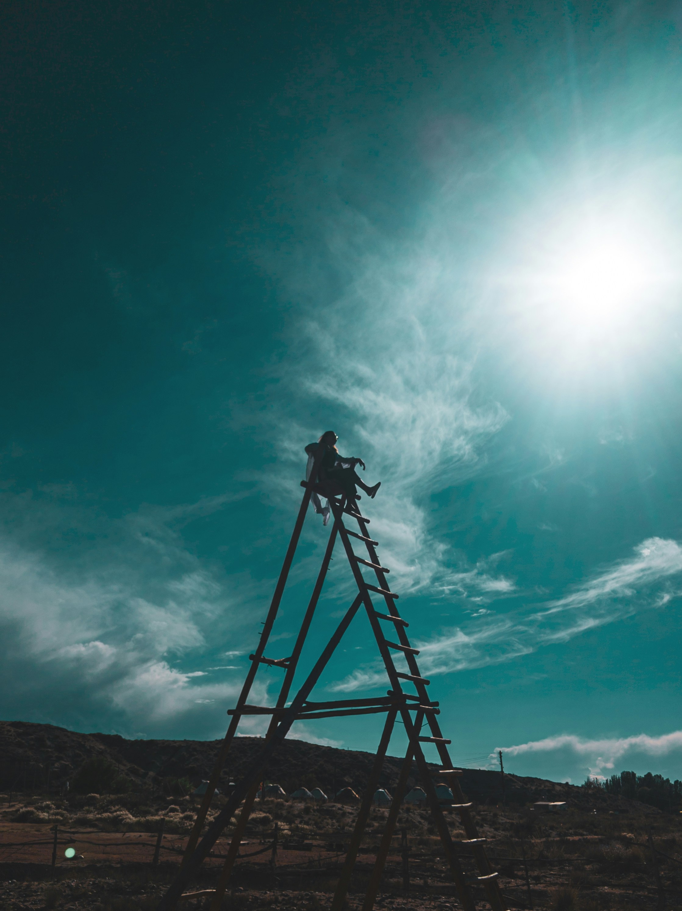 A man on a ladder reaching up into the sky photo – Free Kyrgyzstan ...