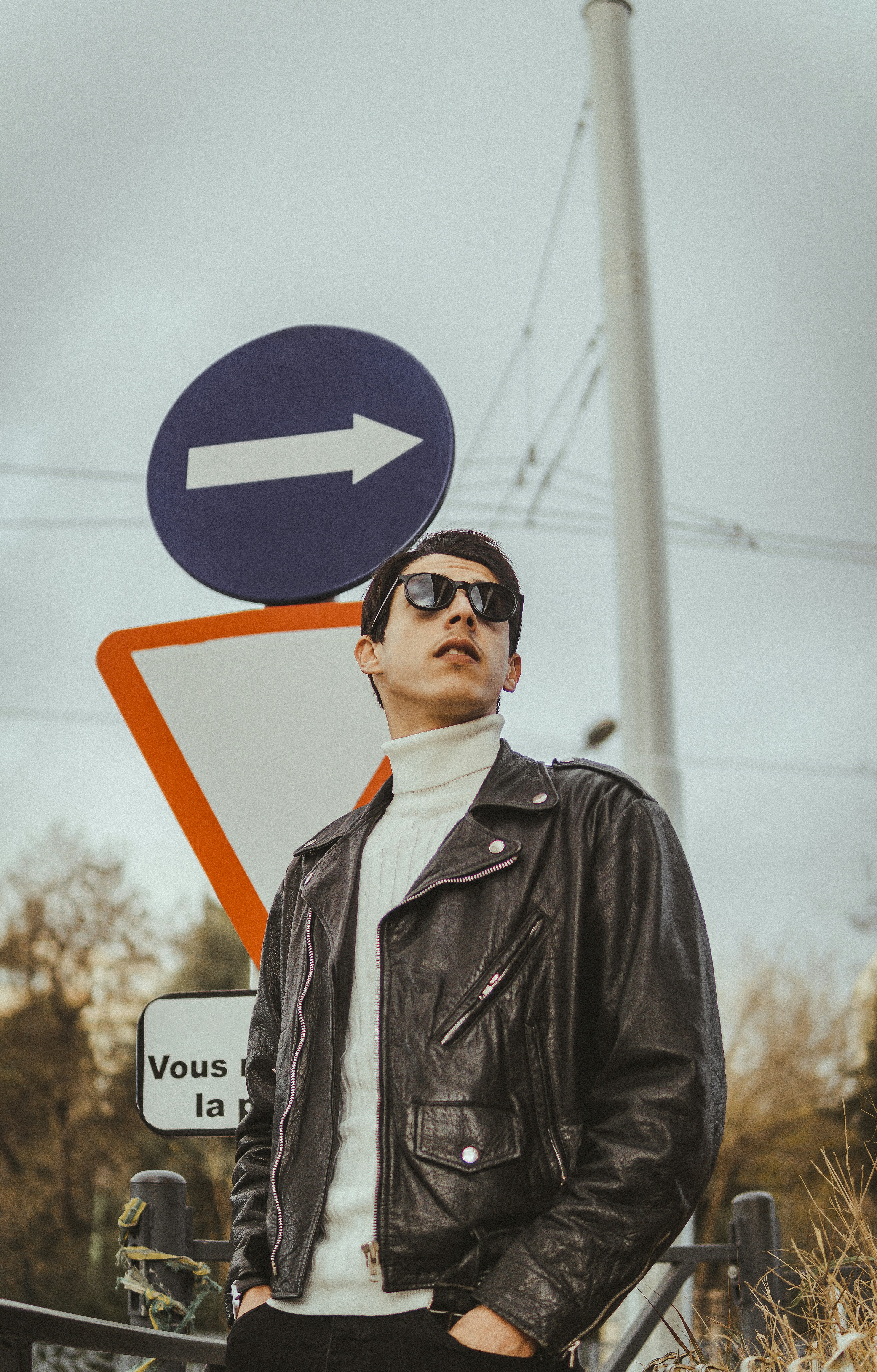 One-Way Gaze: Leather-Clad Portrait Beneath a Right-Arrow Sign