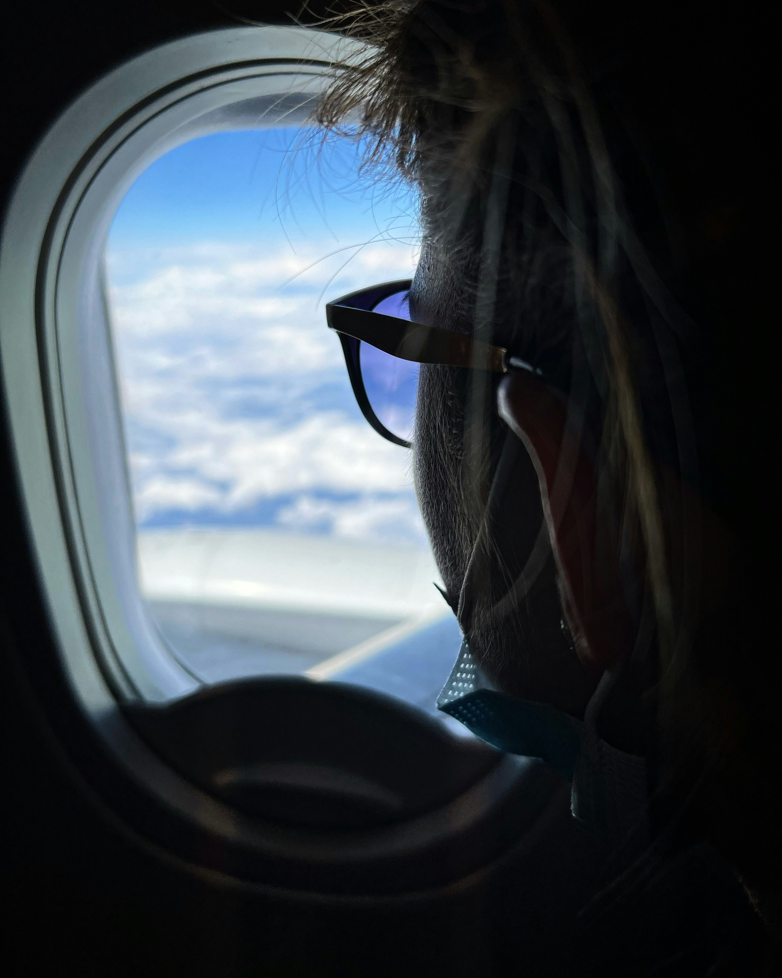 A person looking out of an airplane window photo – Free Blue Image on ...