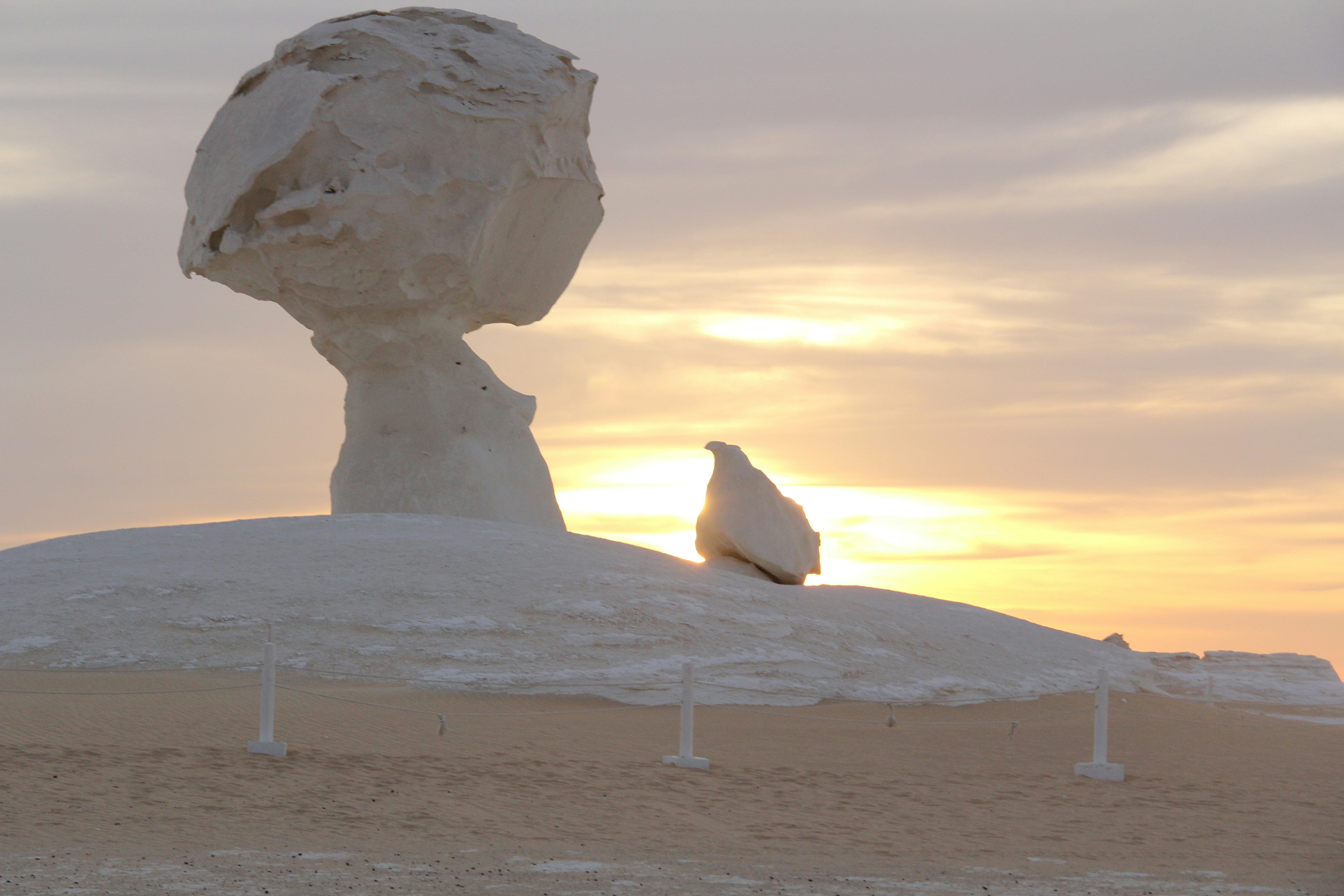 Un gros rocher assis au sommet d’une plage de sable photo – Image ...