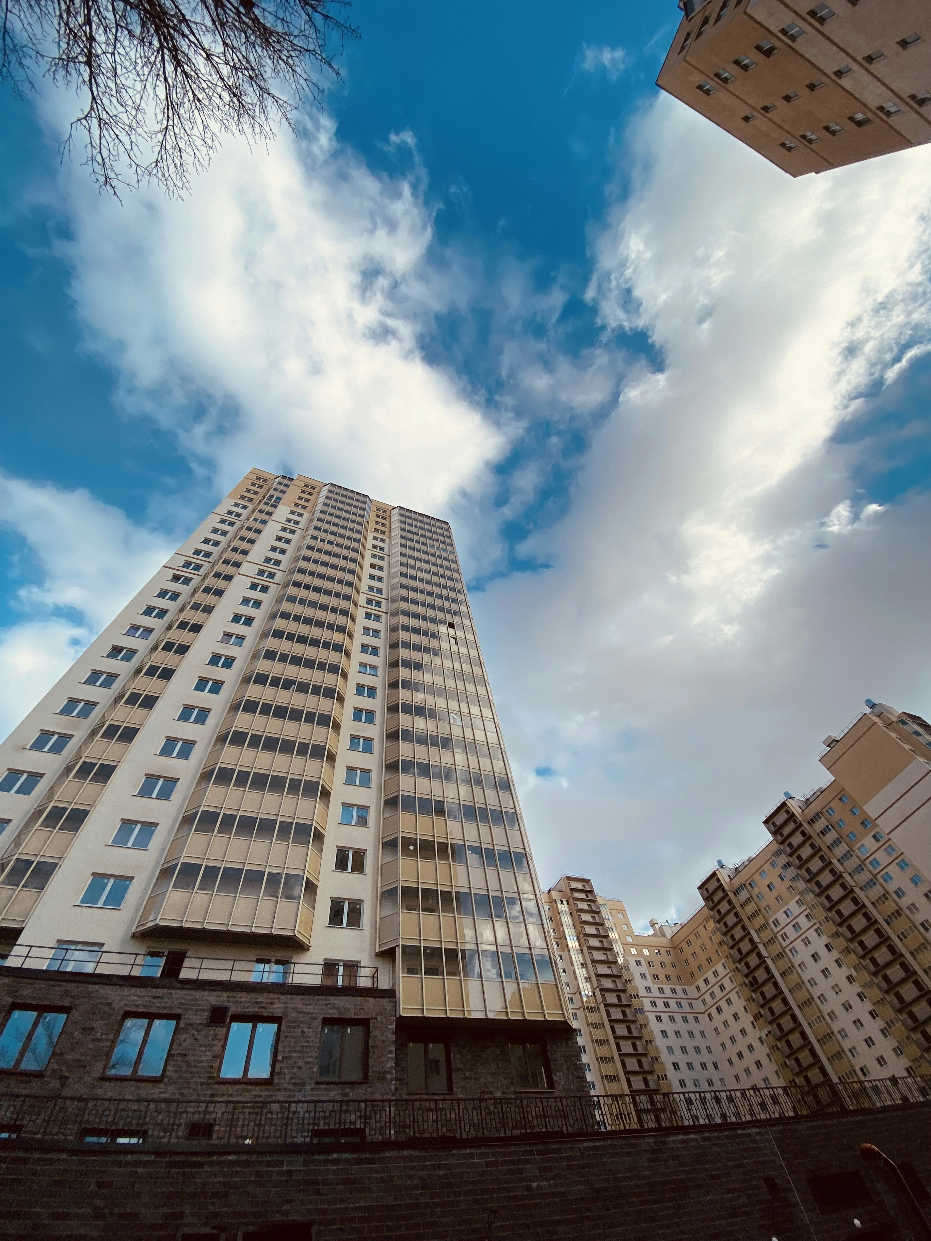 A very tall building sitting next to other tall buildings photo – Free ...
