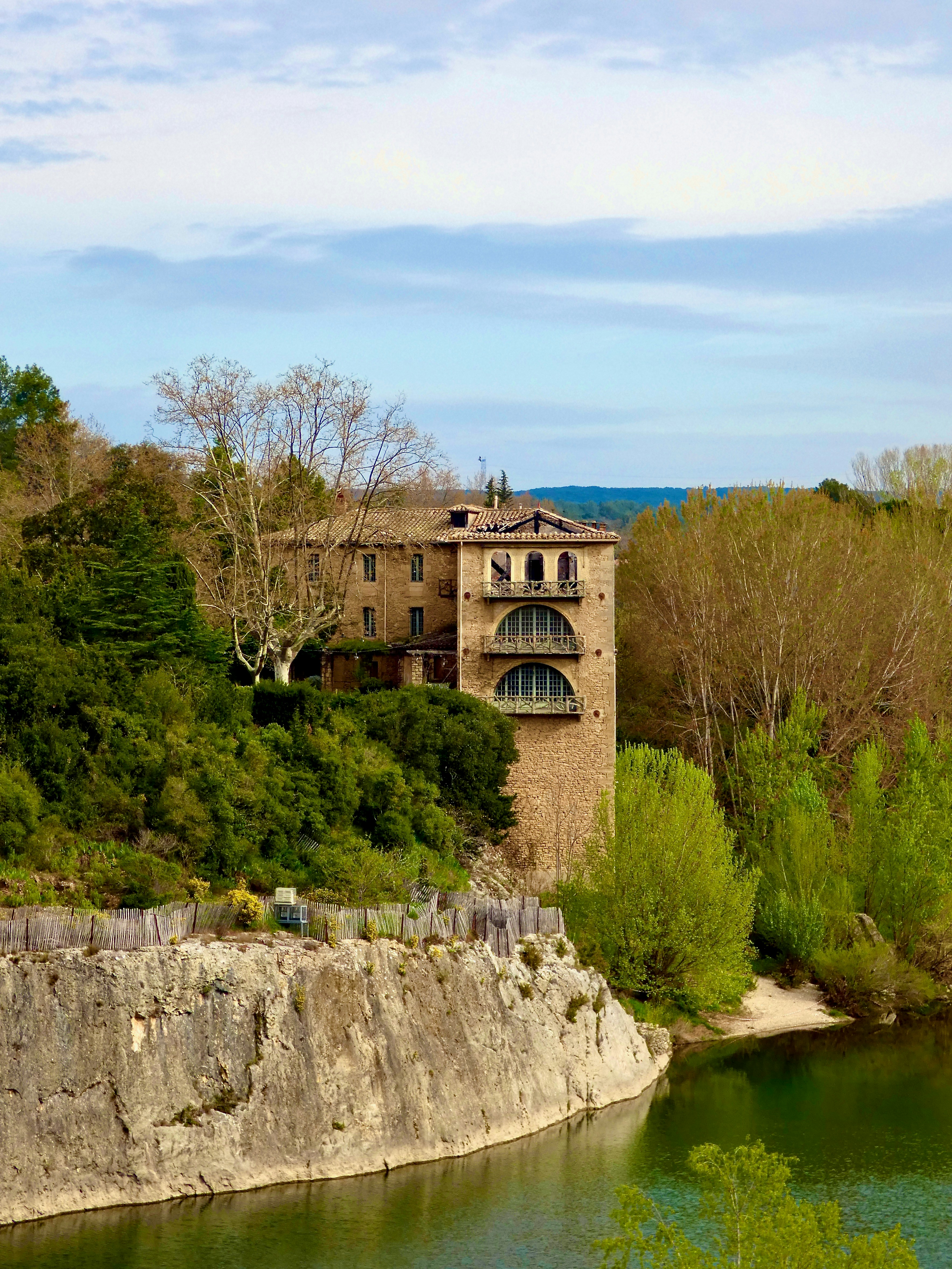 A large building sitting on top of a cliff next to a river photo – Free ...
