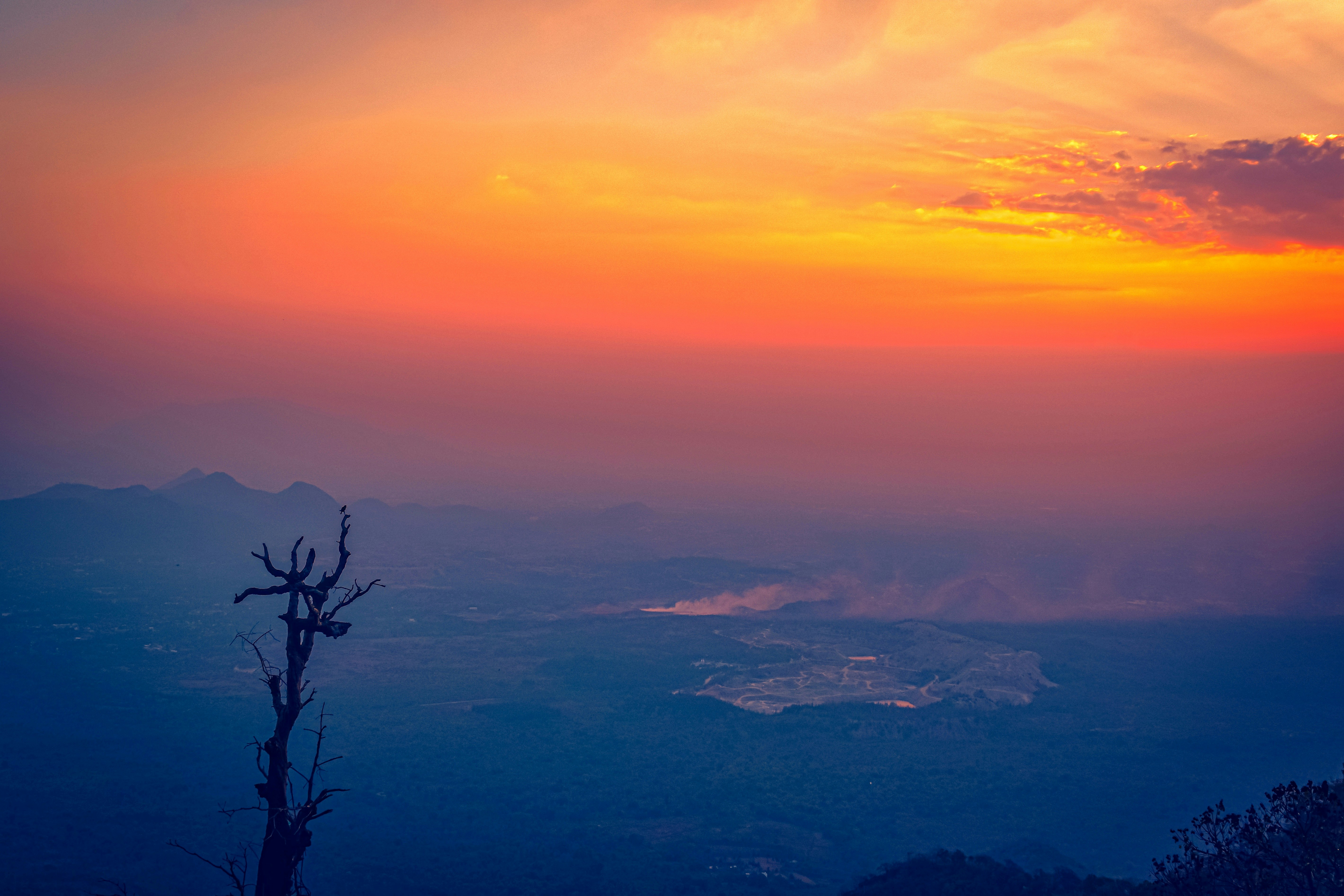 the sun is setting over a mountain range