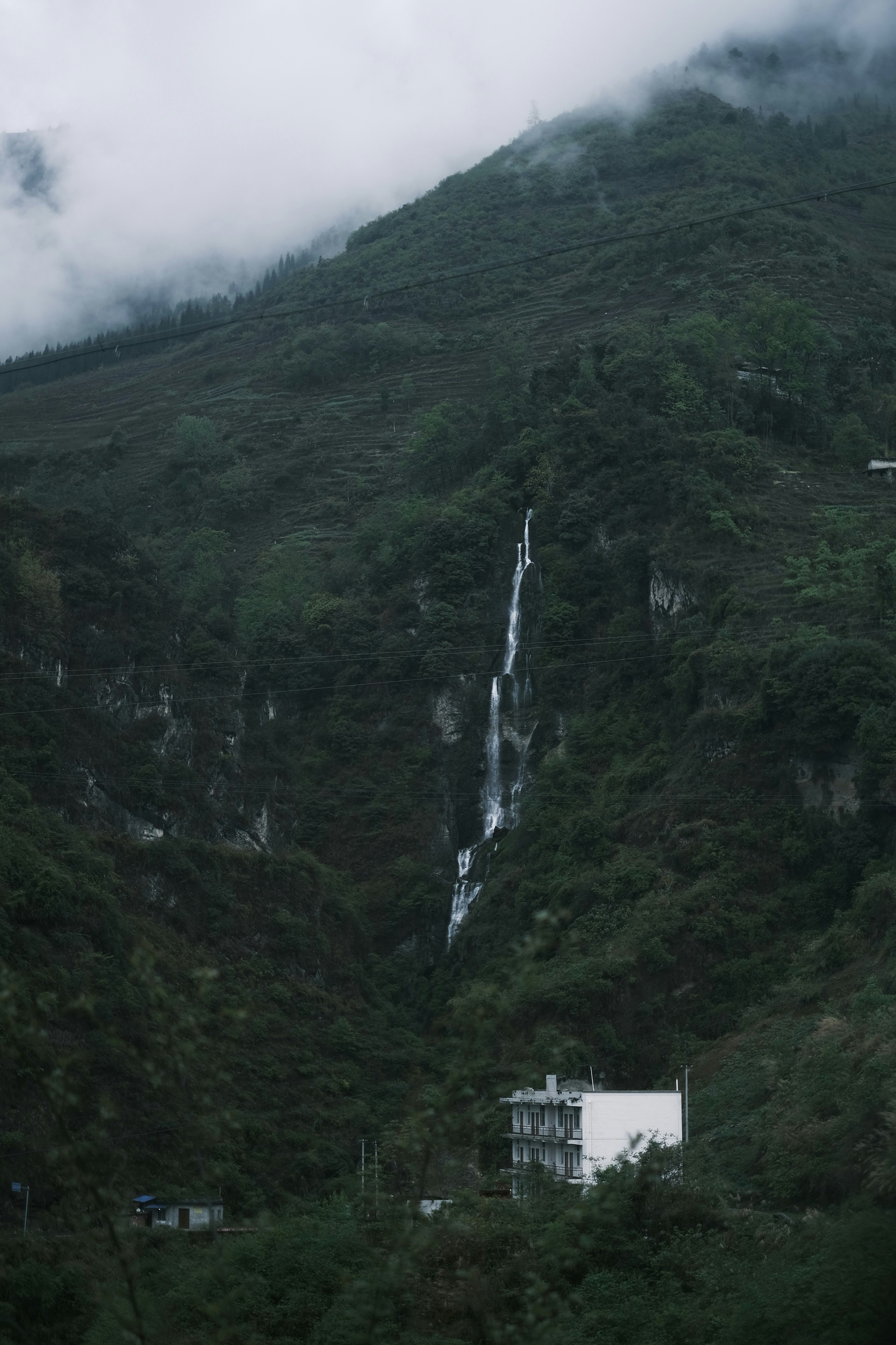 a tall mountain with a waterfall in the middle of it