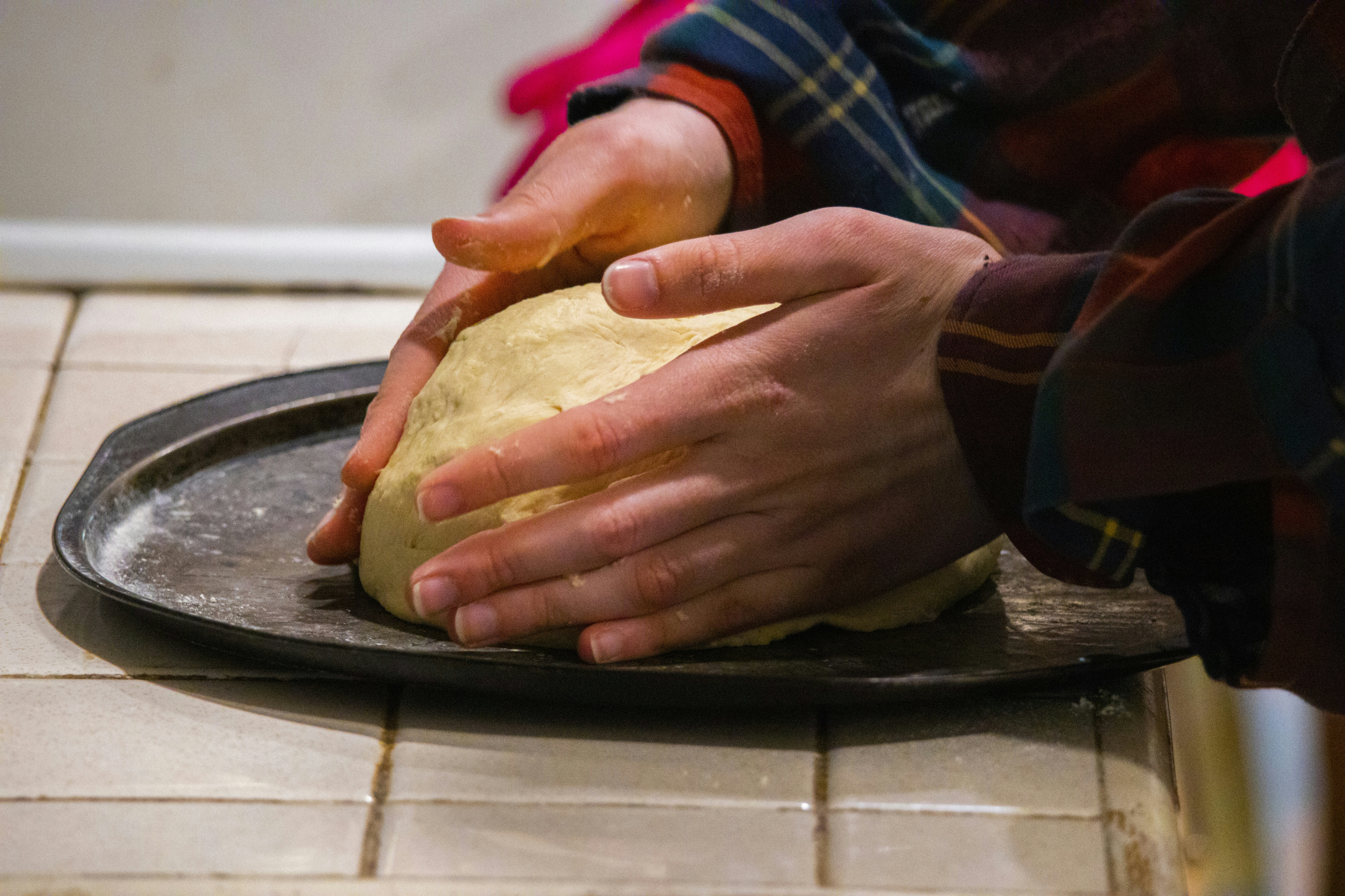 A person kneading a ball of bread on a pan photo – Free Dough Image on ...