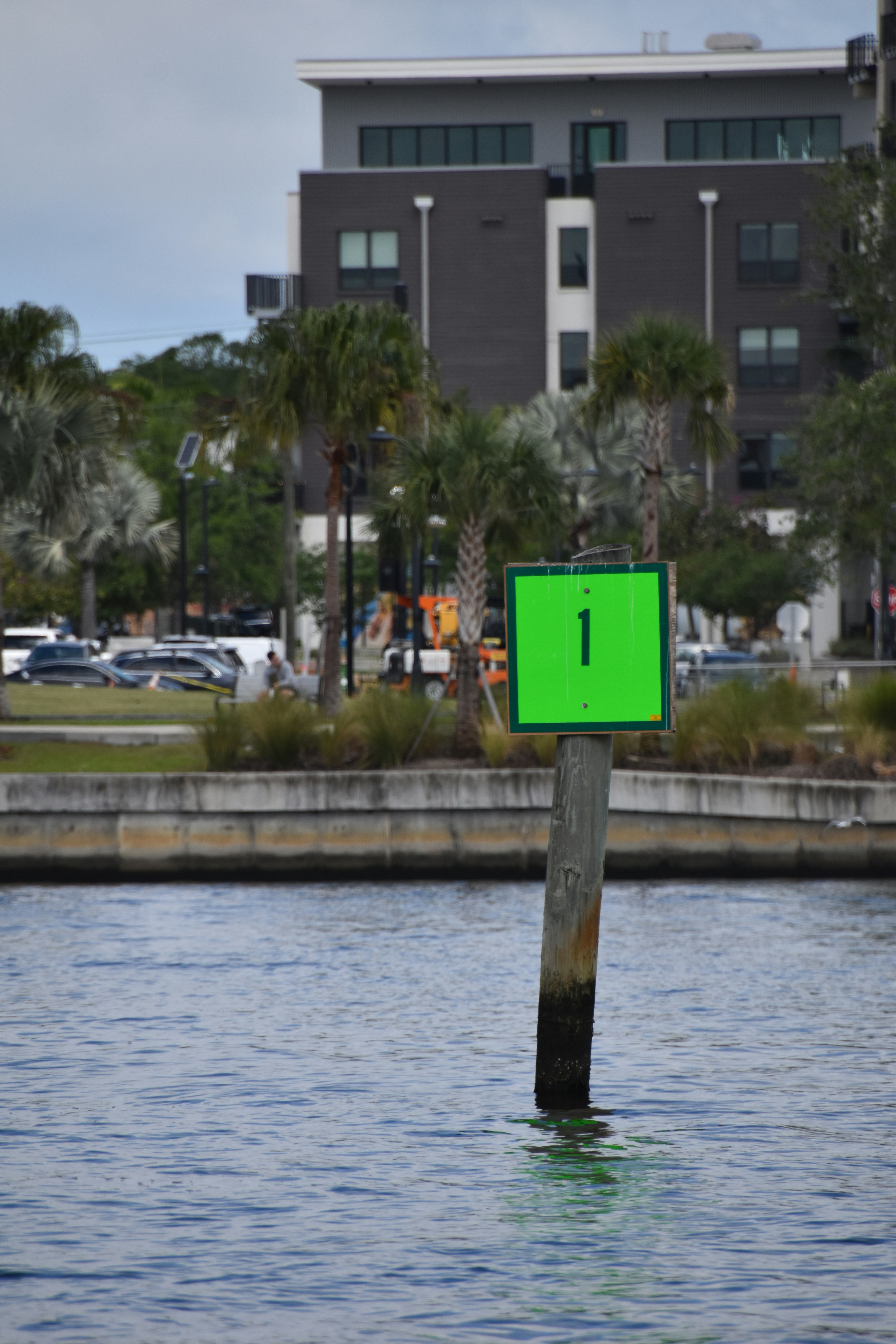 Neon Green Signpost Over Water: A Quiet Marina Marker