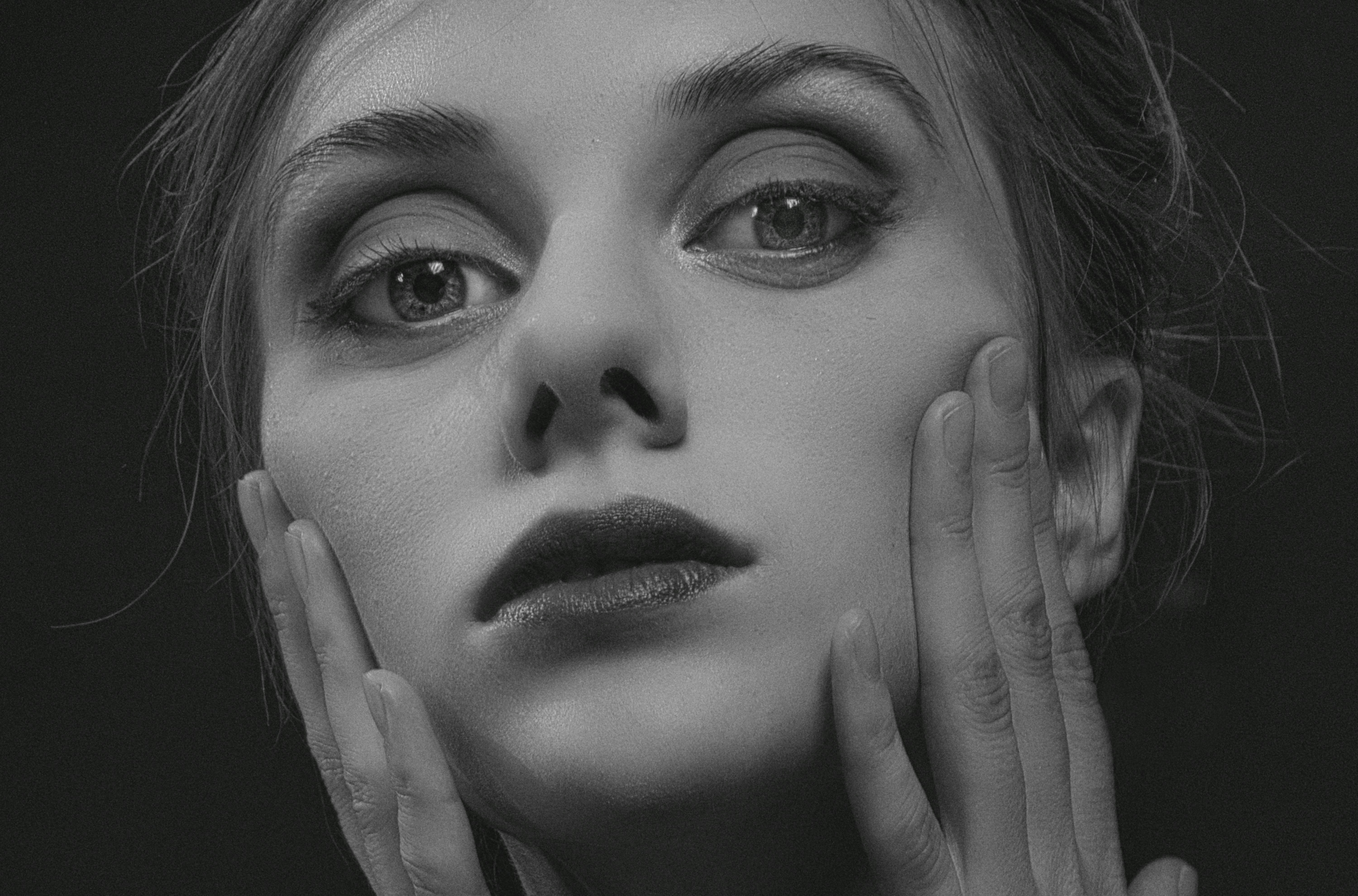 Une photo en noir et blanc d’une femme avec ses mains sur son visage ...
