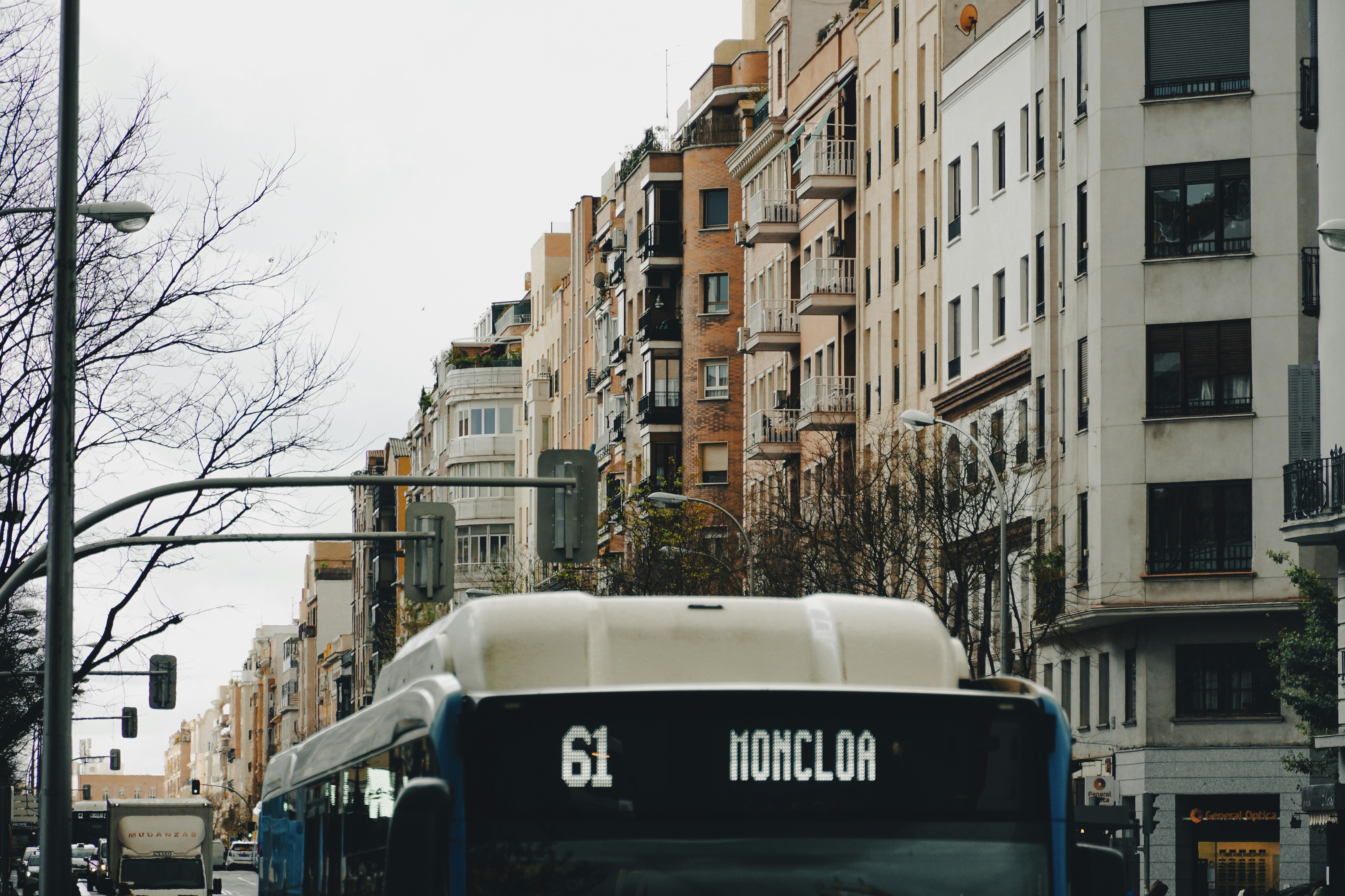 City Bus in Focus: A Rainy Street Soaked in Urban Geometry