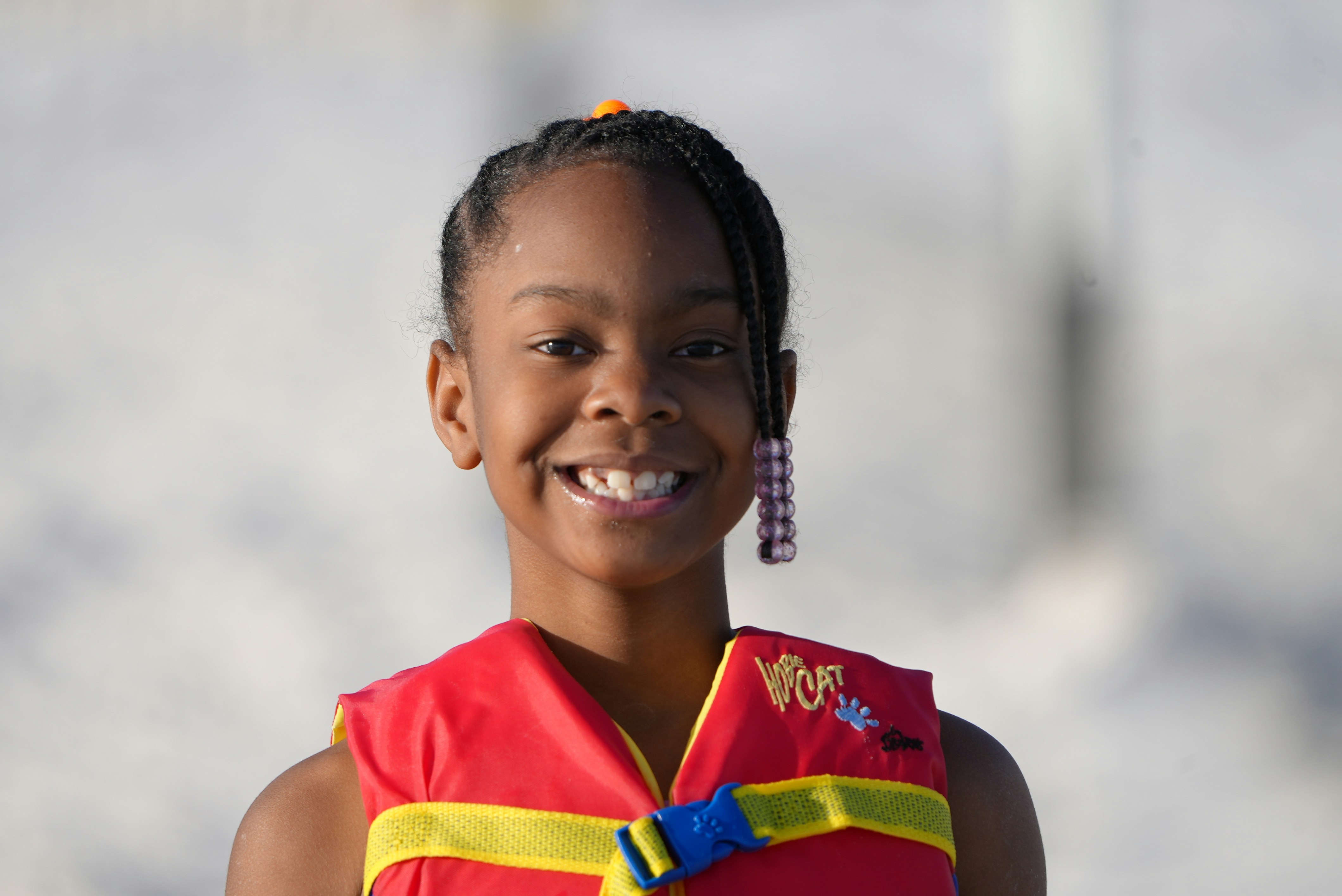 A young girl in a red life jacket smiles at the camera photo – Free ...