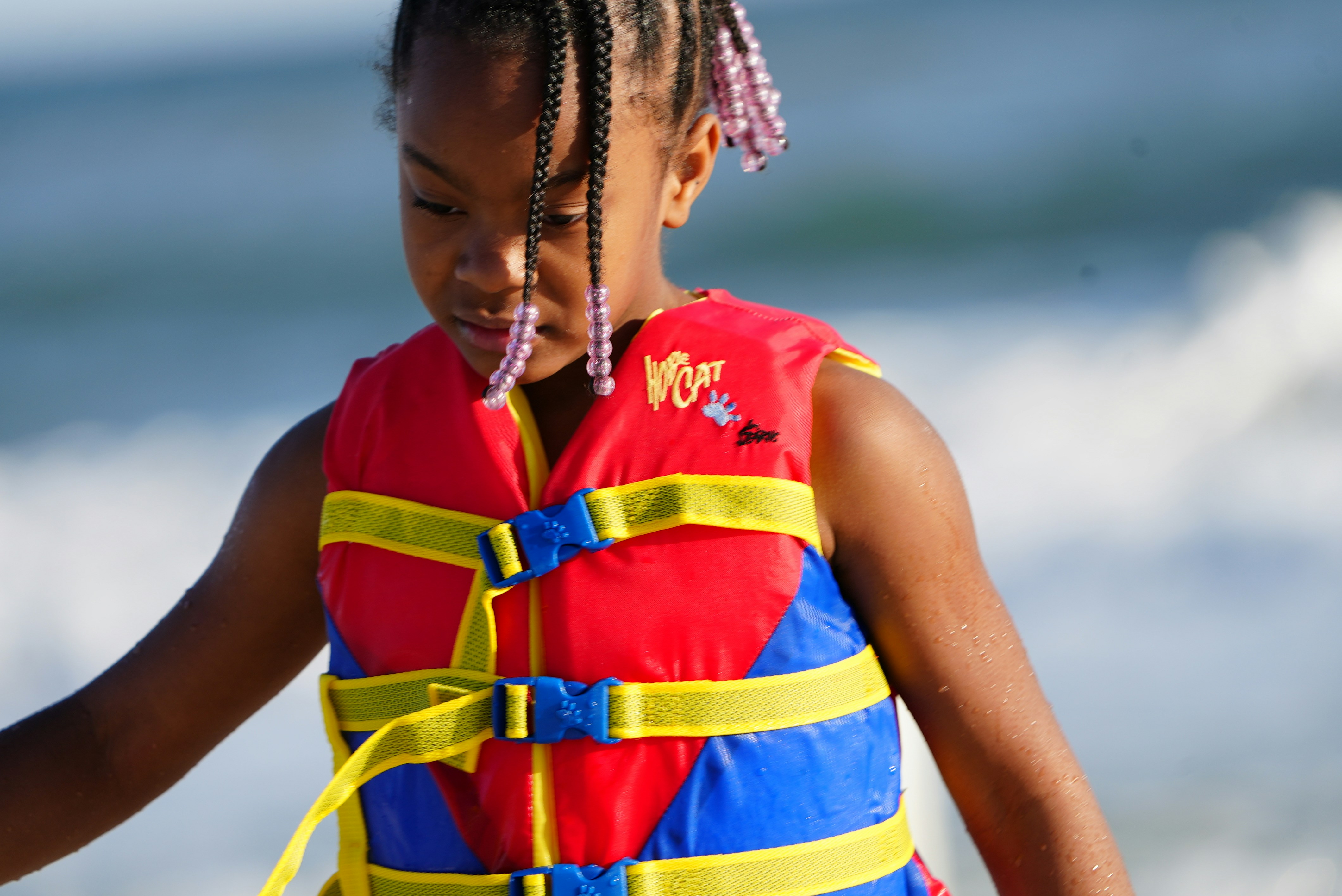 A little girl wearing a life jacket on the beach photo – Free ...