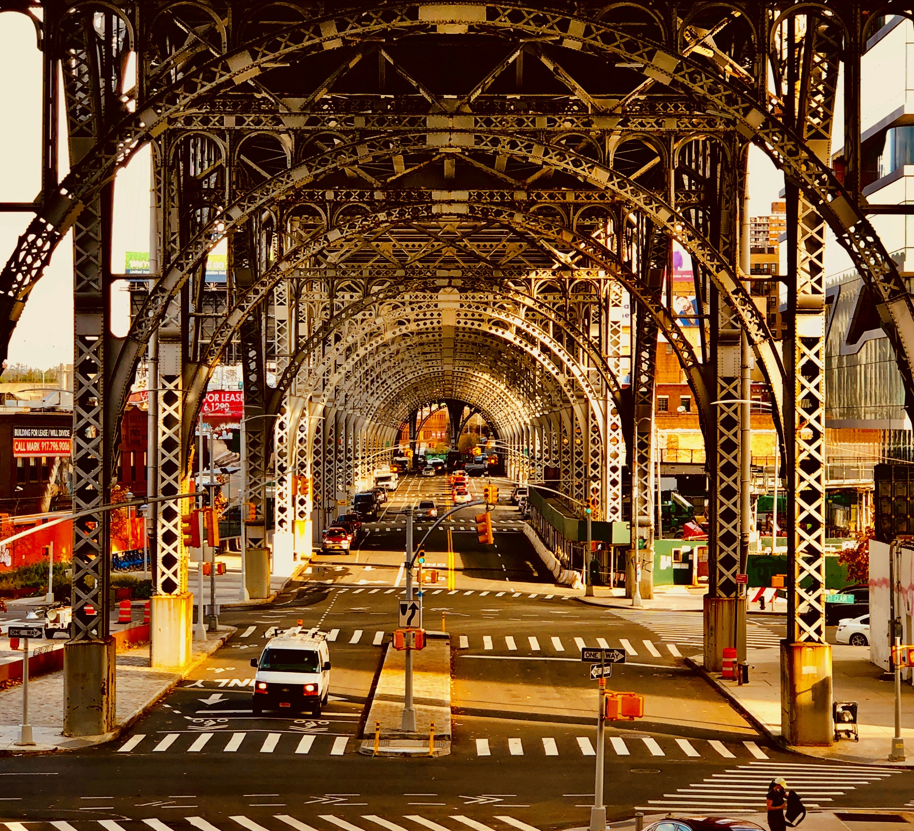 A city street with a train going under a bridge photo – Free New york ...