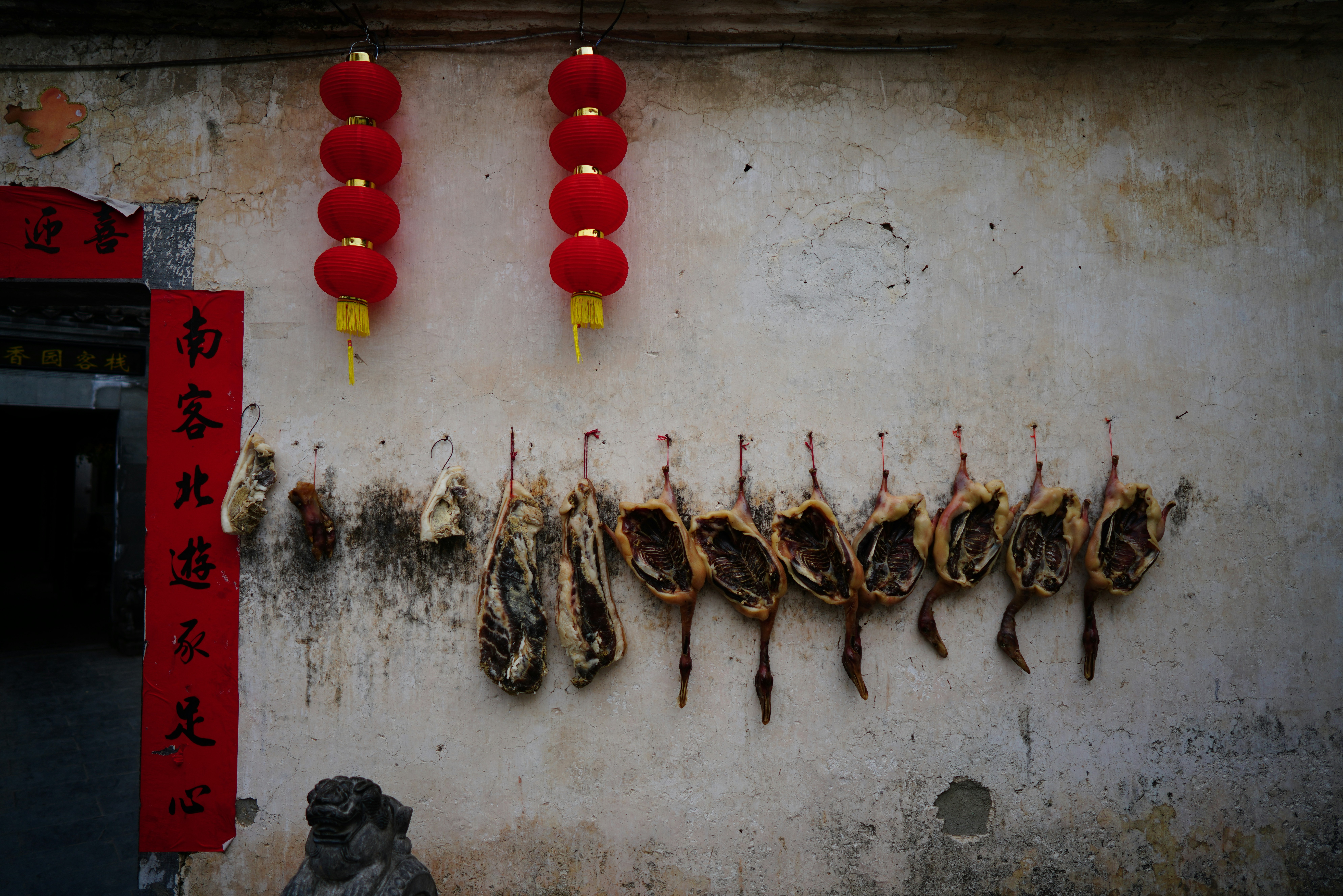 Red Lanterns and Dried Bounties on a Humble Wall
