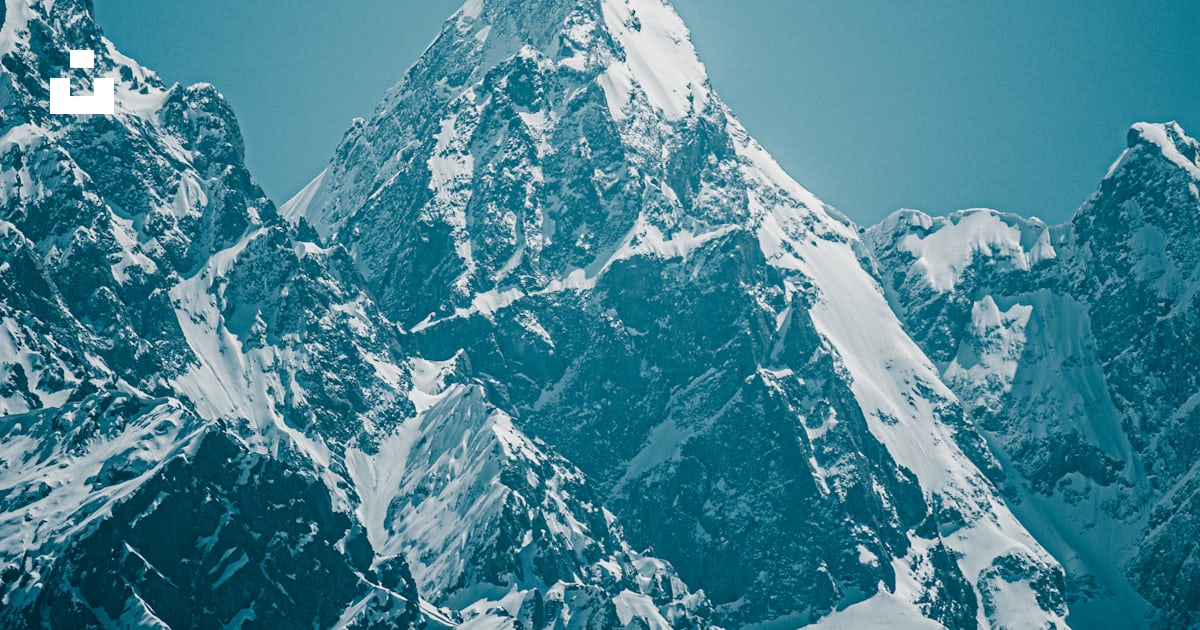 Une Grande Montagne Couverte De Neige Sous Un Ciel Bleu Photo Photo