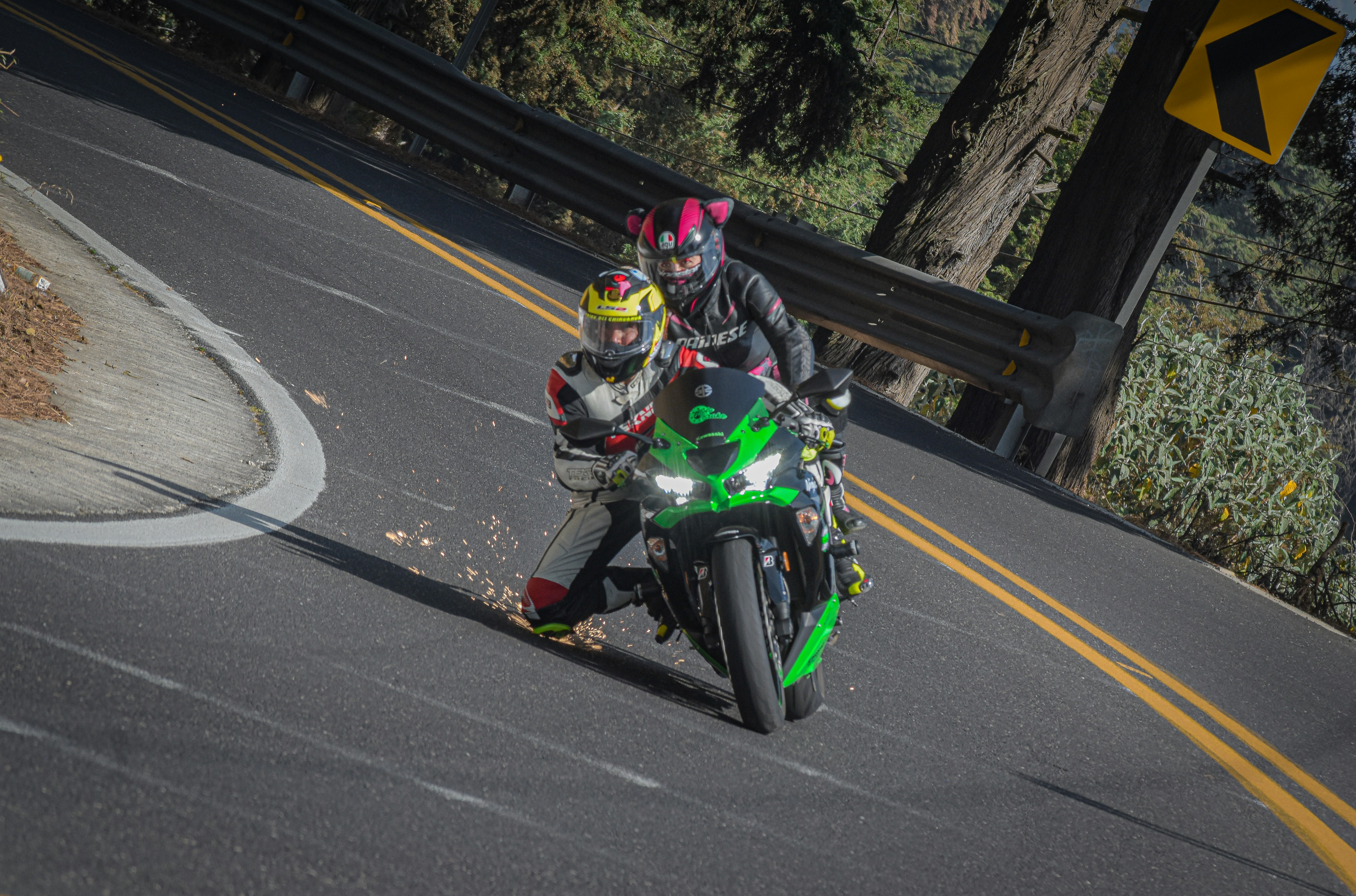 A couple of people riding on the back of a green motorcycle photo ...