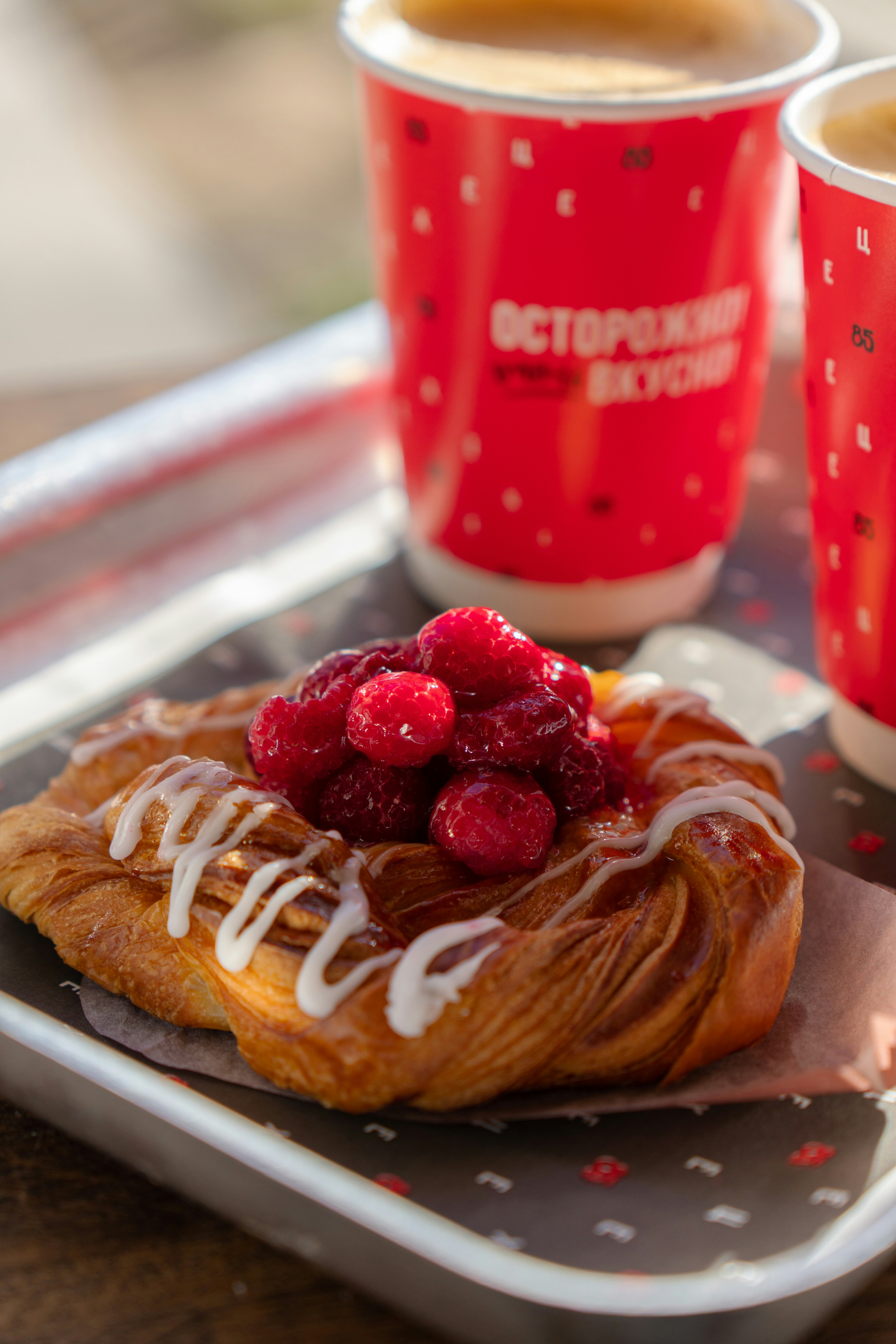 a pastry and two cups of coffee on a tray