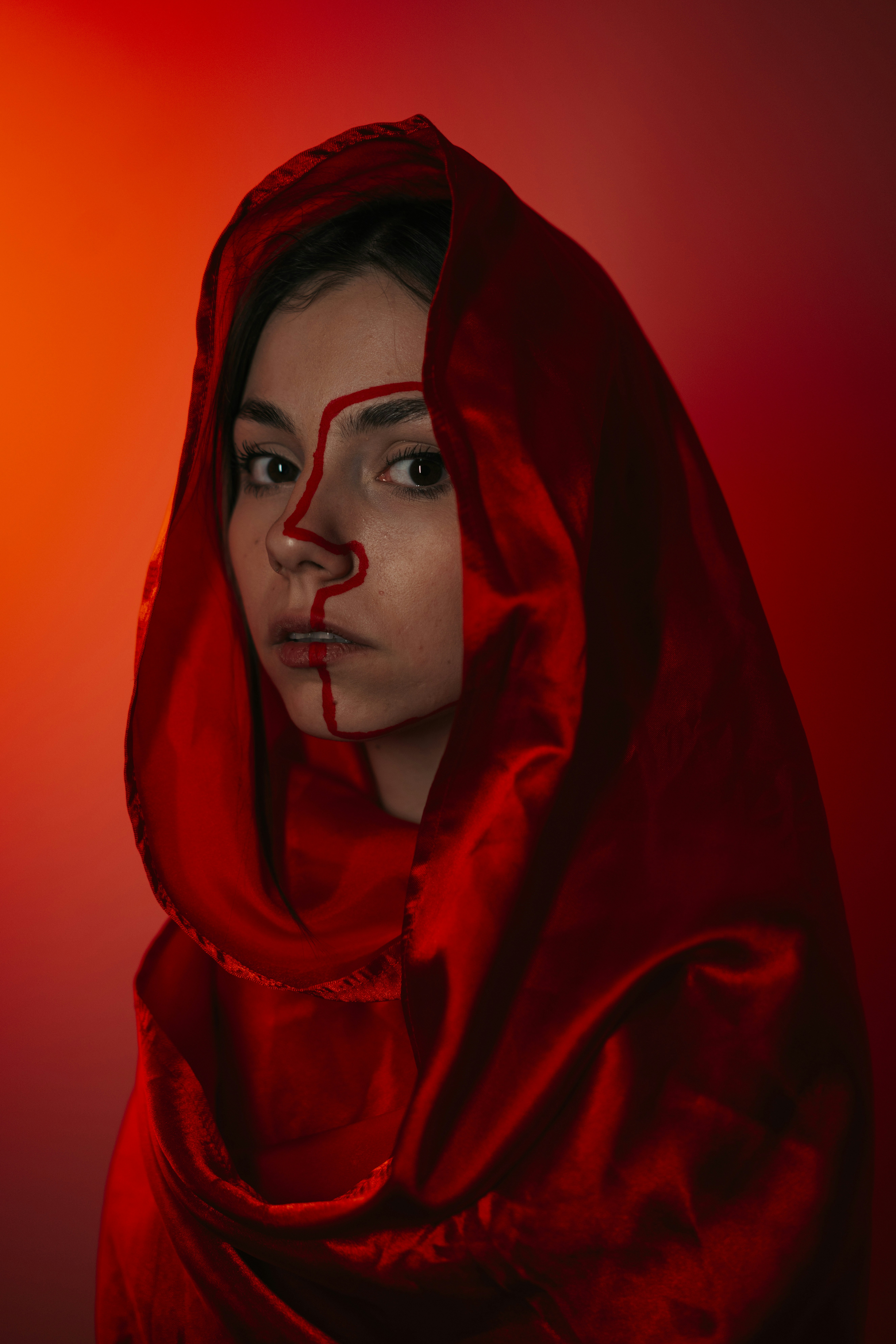 A woman in a red cloak with a red face paint photo – Free Fashion Image ...