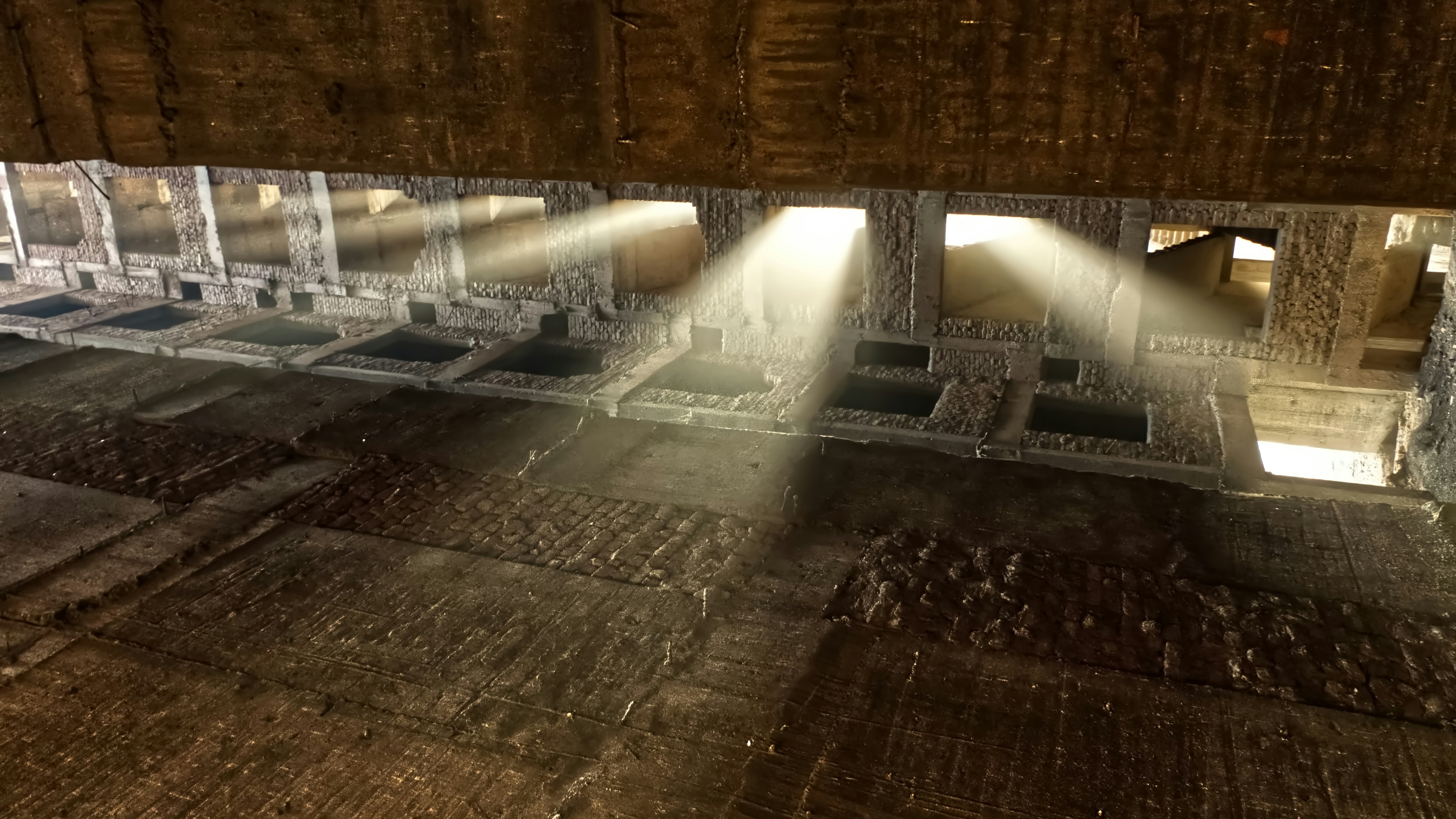Sunbeams through ancient stone arches into a sunlit chamber