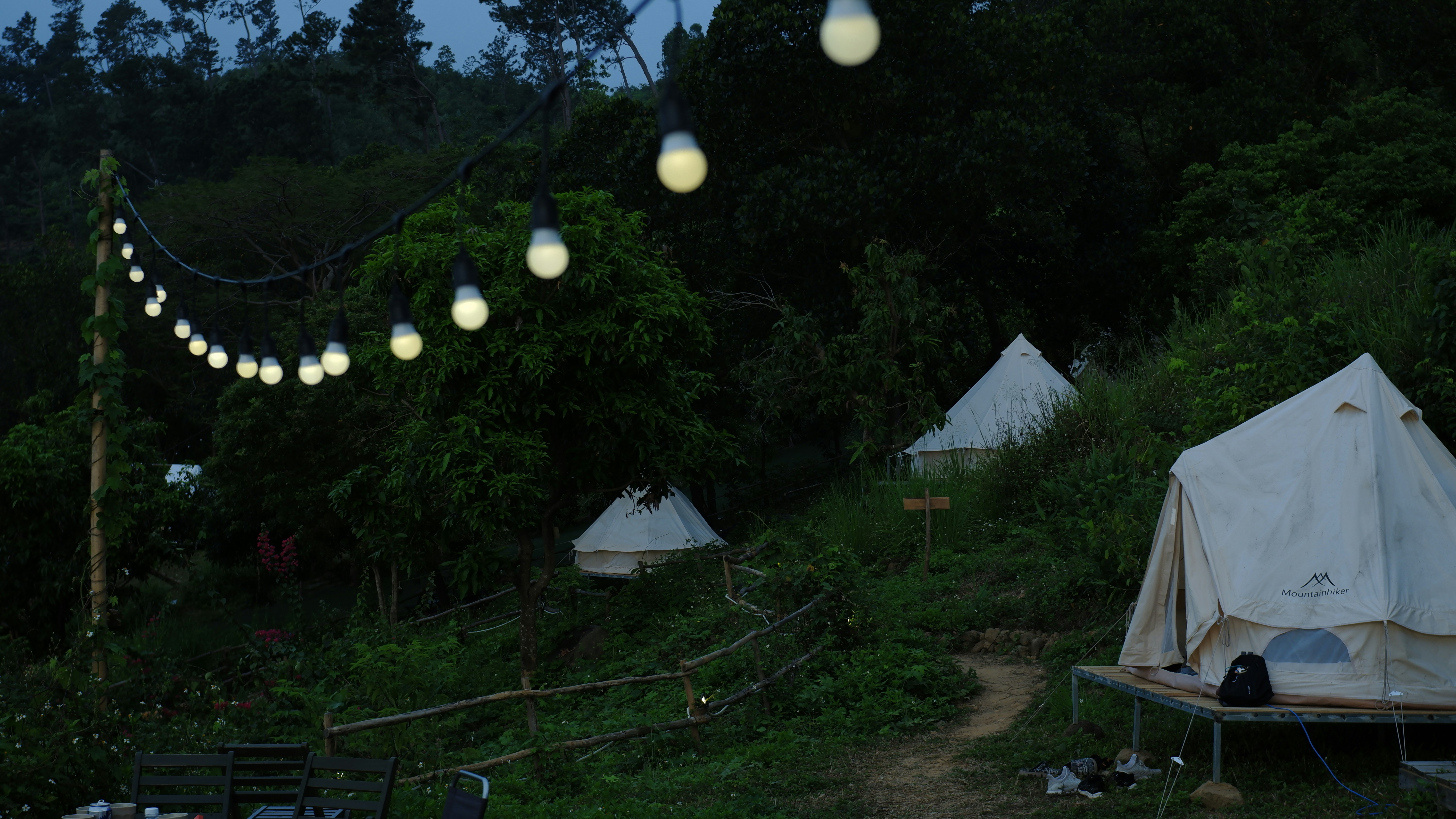 Lanterns Over a Tented Clearing: Night Camp in Soft Gold