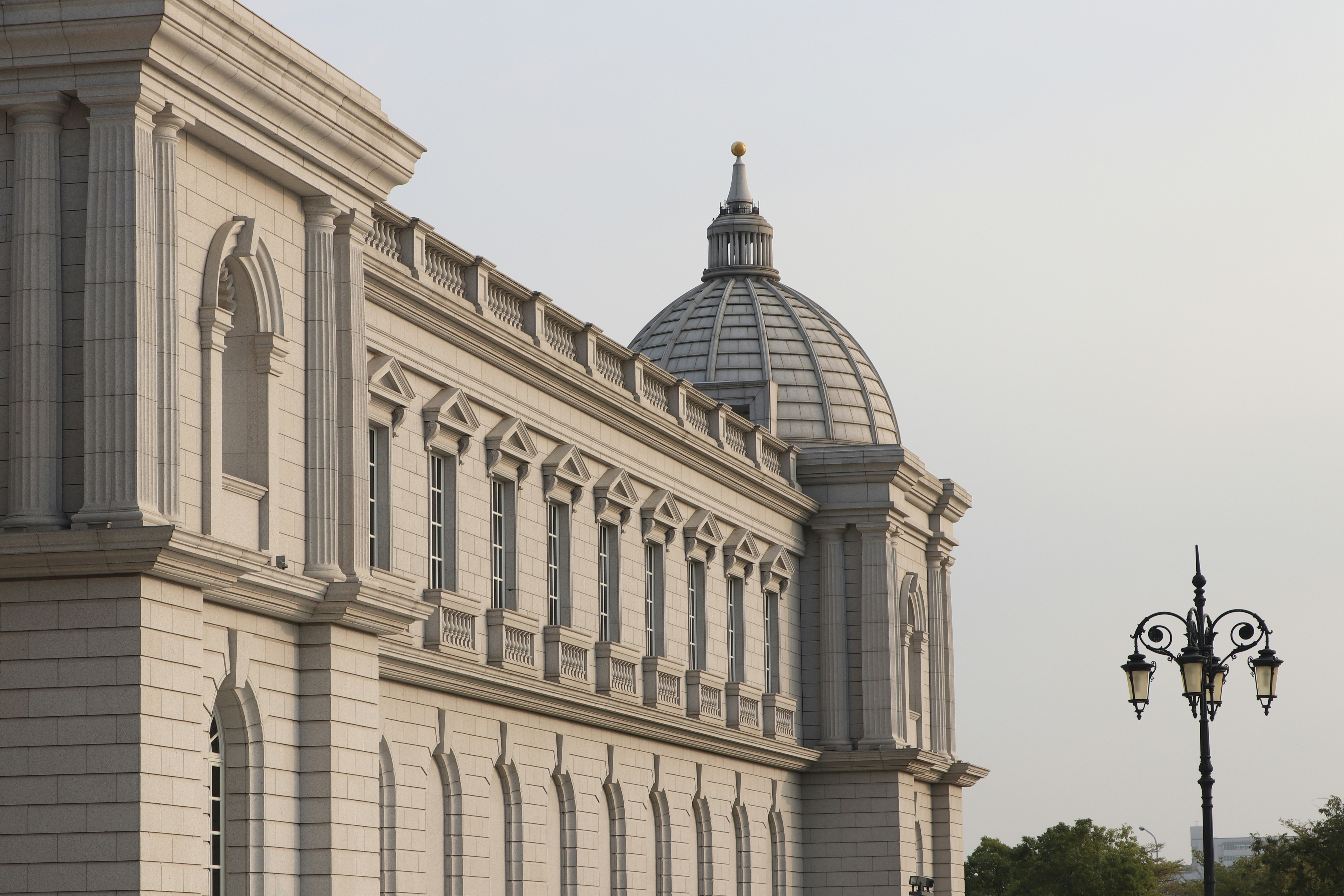 Neoclassical building with a domed roof and ornate architectural details under a clear sky.