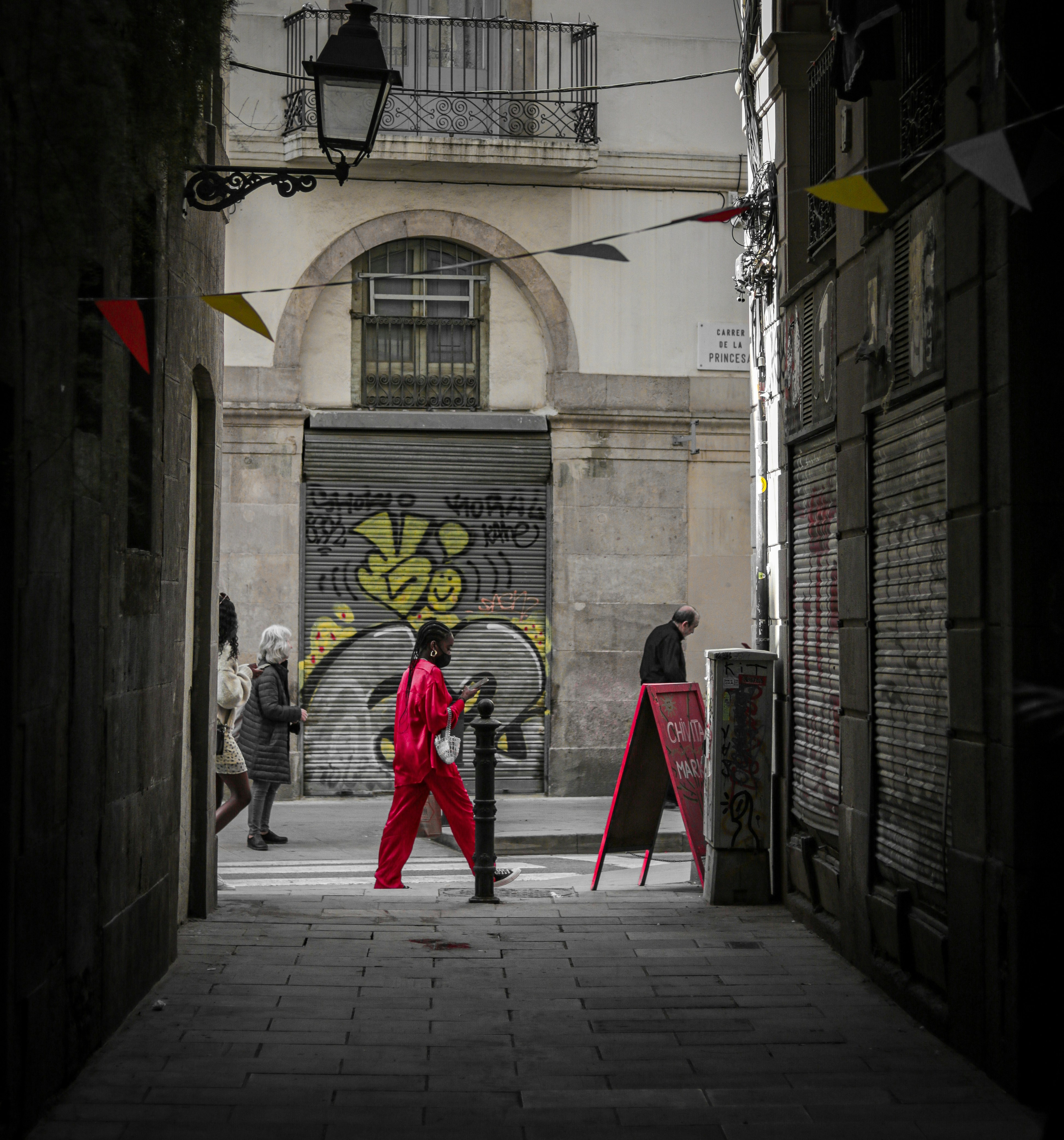 A person in a red outfit walking down a street photo – Free Street ...