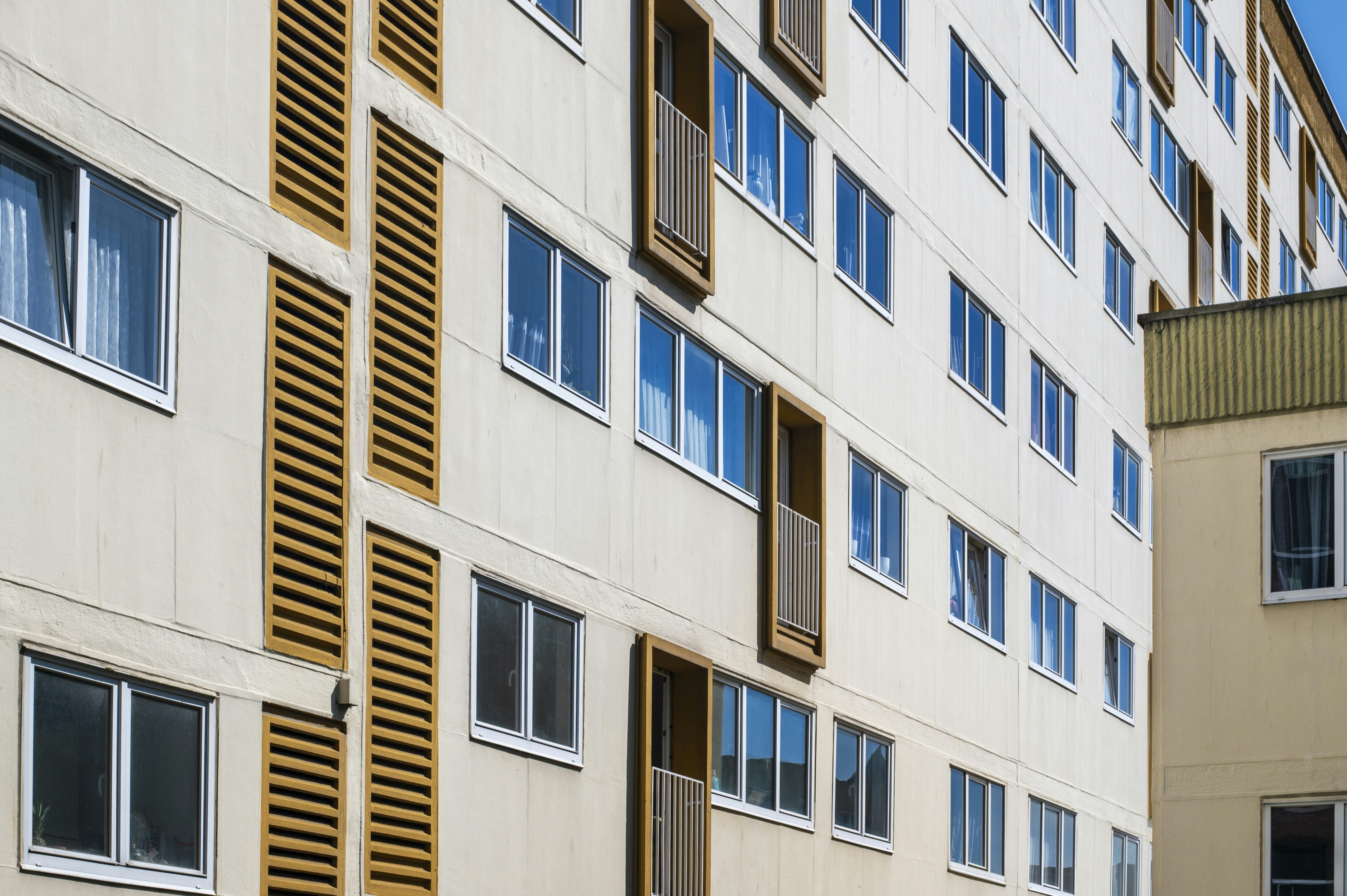 A tall building with many windows and shutters photo – Free Sint ...