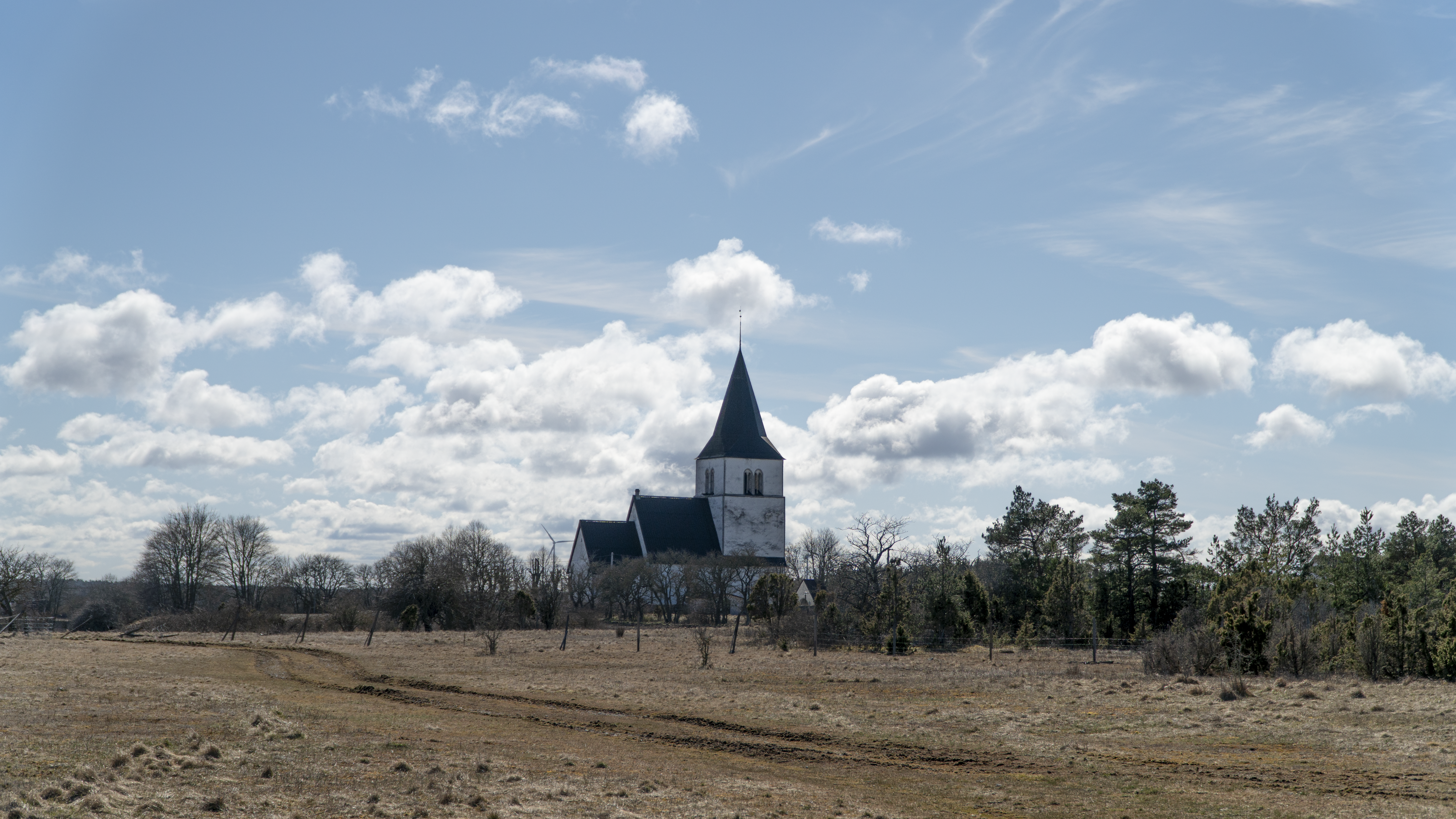 Church Spire Above the Open Prairie Under a Cloudy Blue Sky