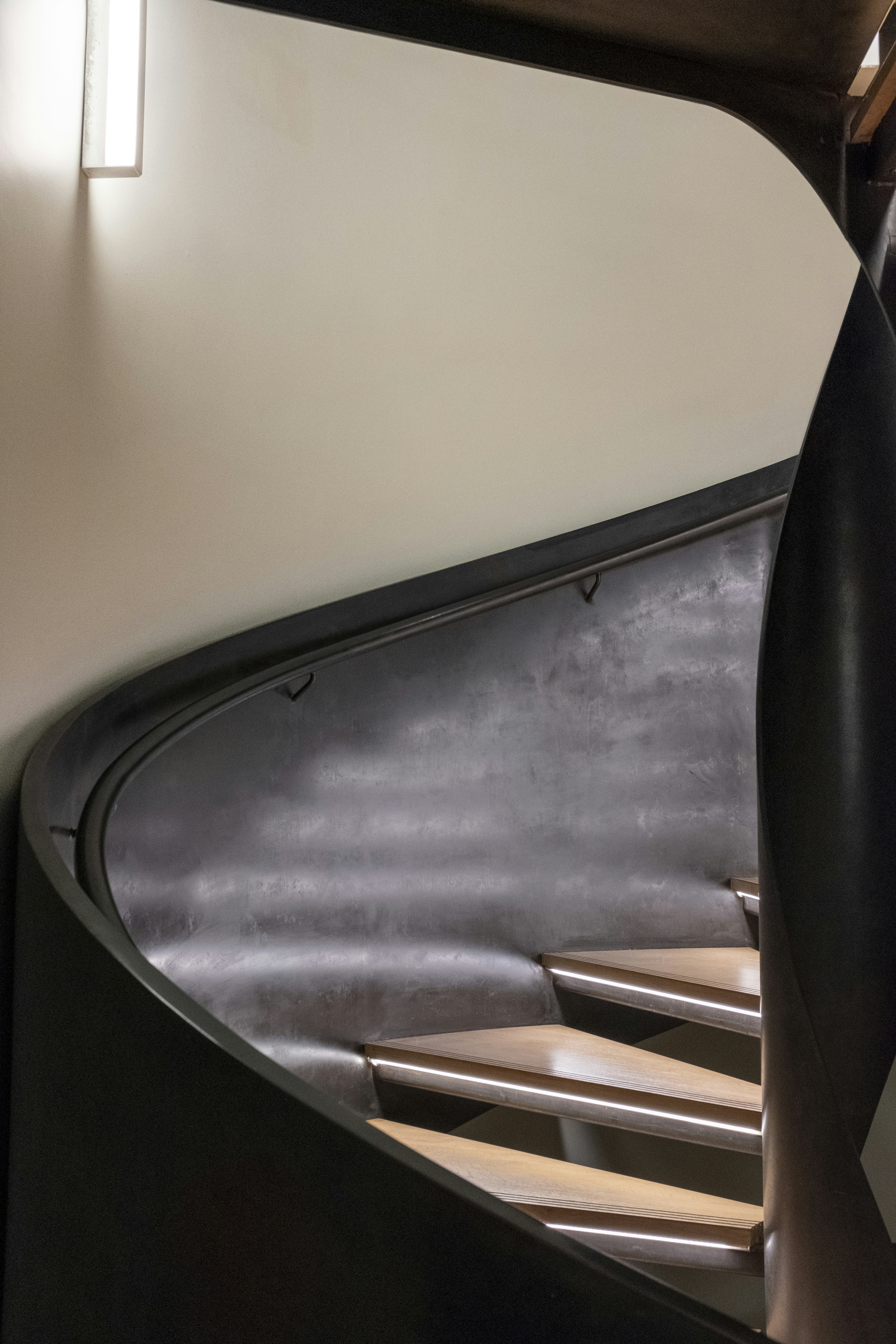 A curved metal staircase with a light above it photo – Free Villa du ...